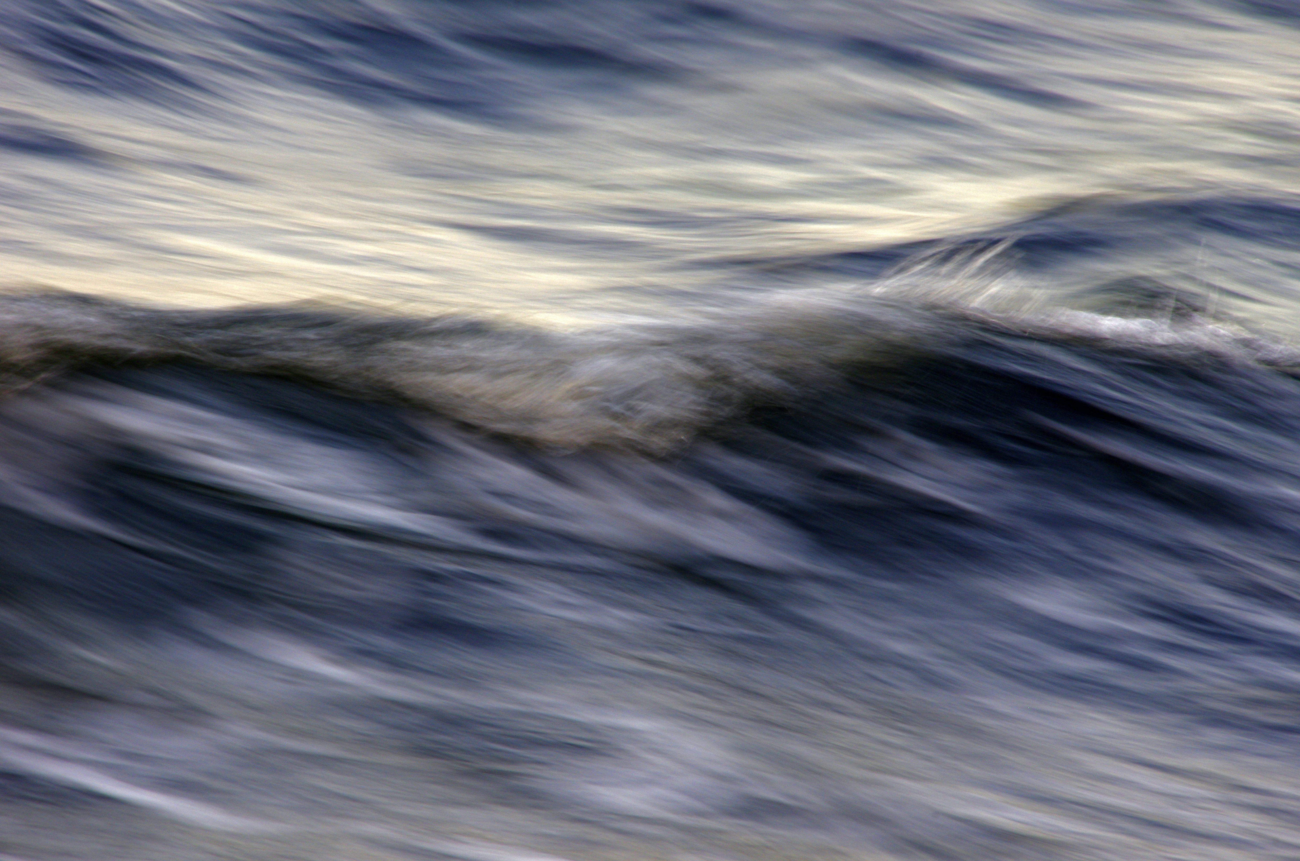 Abstract long exposure of sea waves creating a blurred, flowing effect.