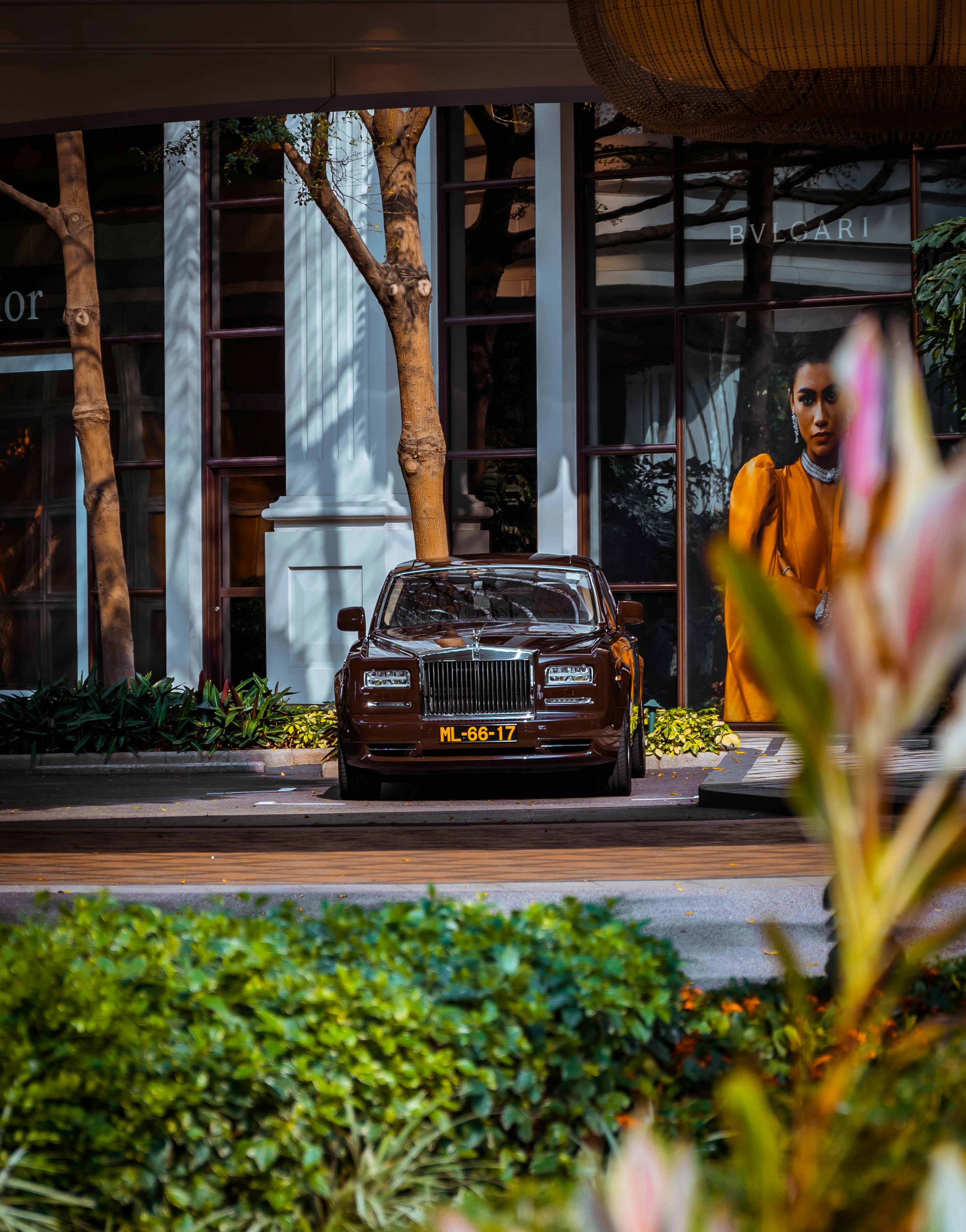 Man in yellow dress shirt standing beside black car during daytime ...