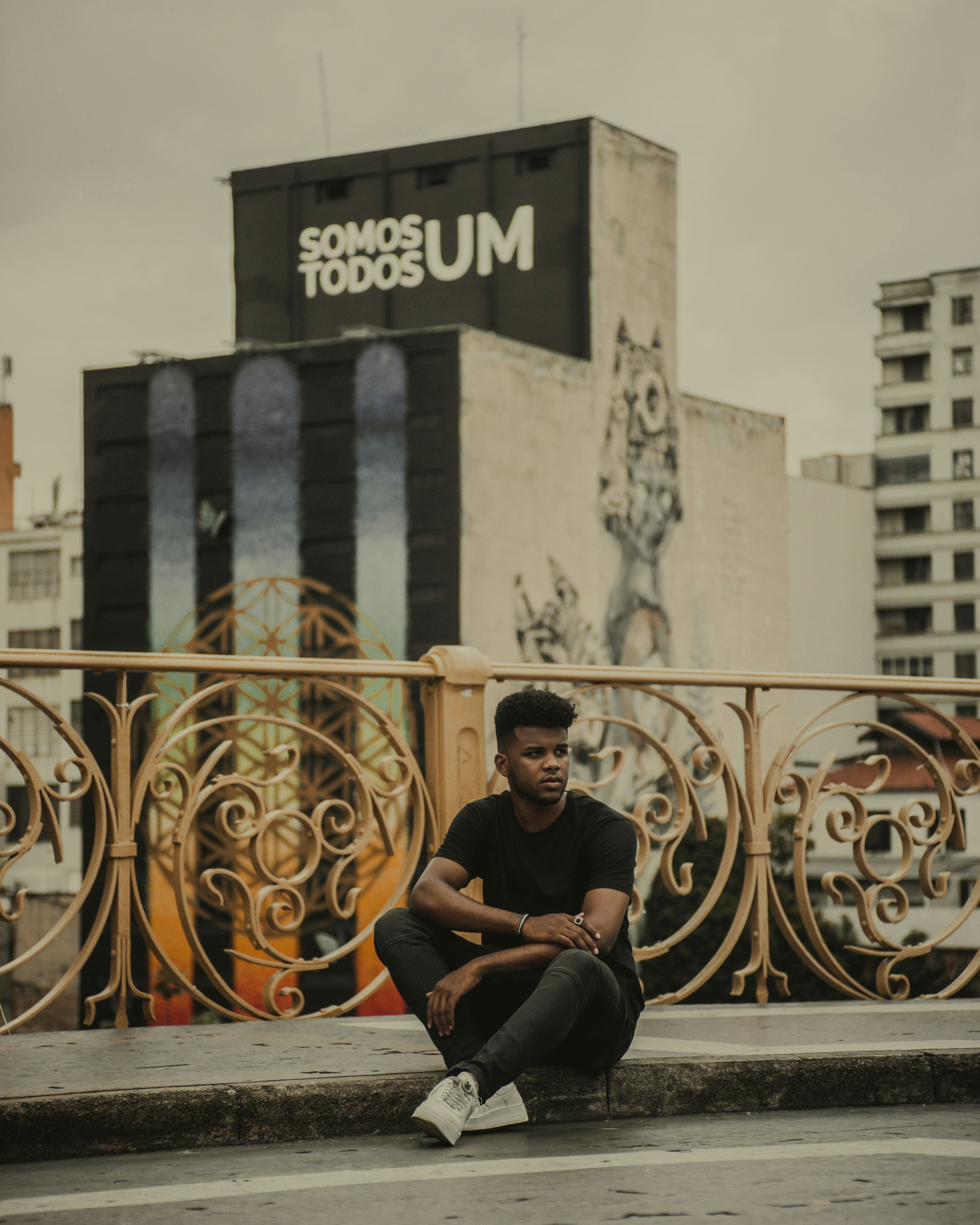 Midday stillness on the bridge: a contemplative portrait against muraled facades