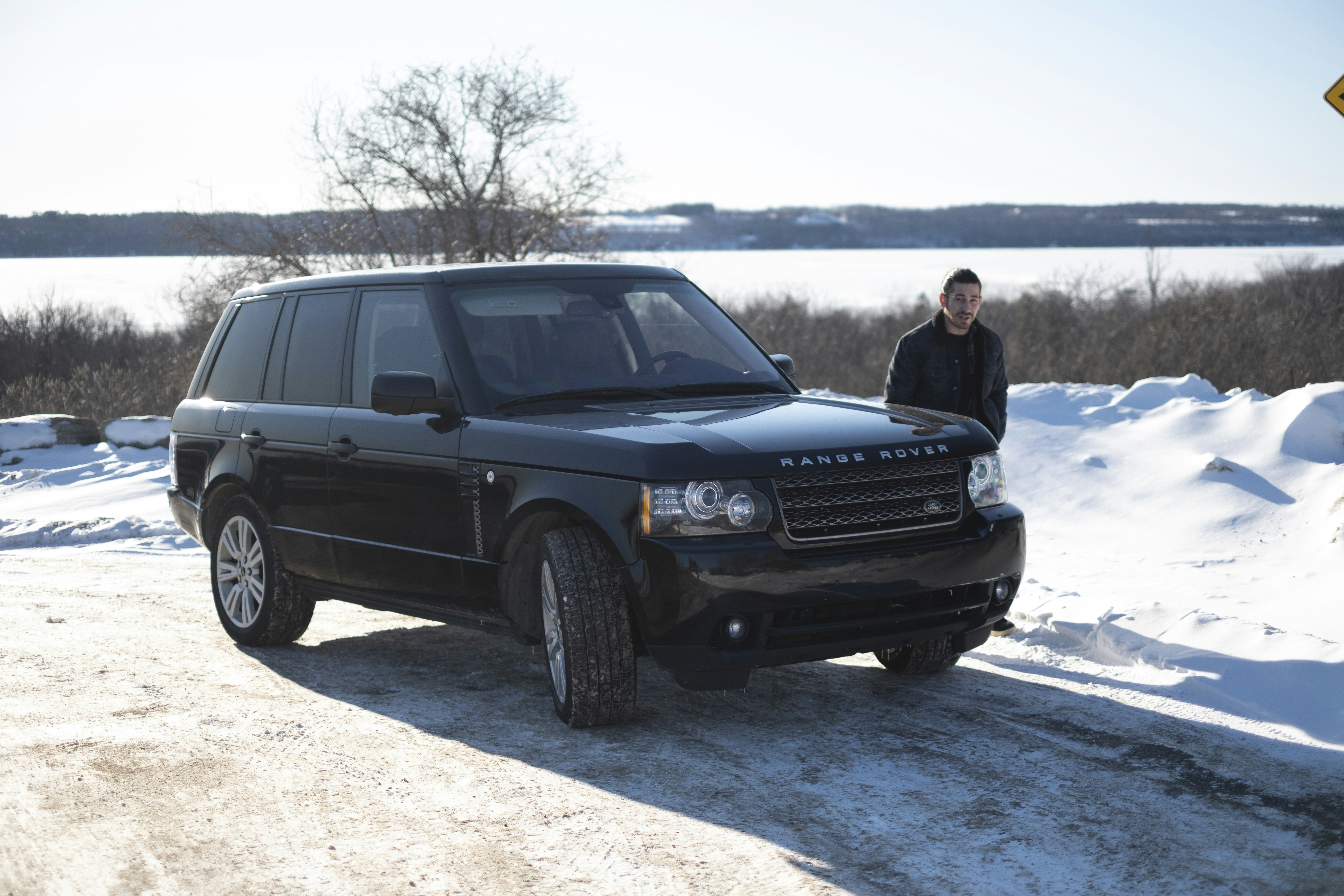 Midwinter Standstill: A Black Range Rover Anchors a Snow-Blanketed Lakeside Road