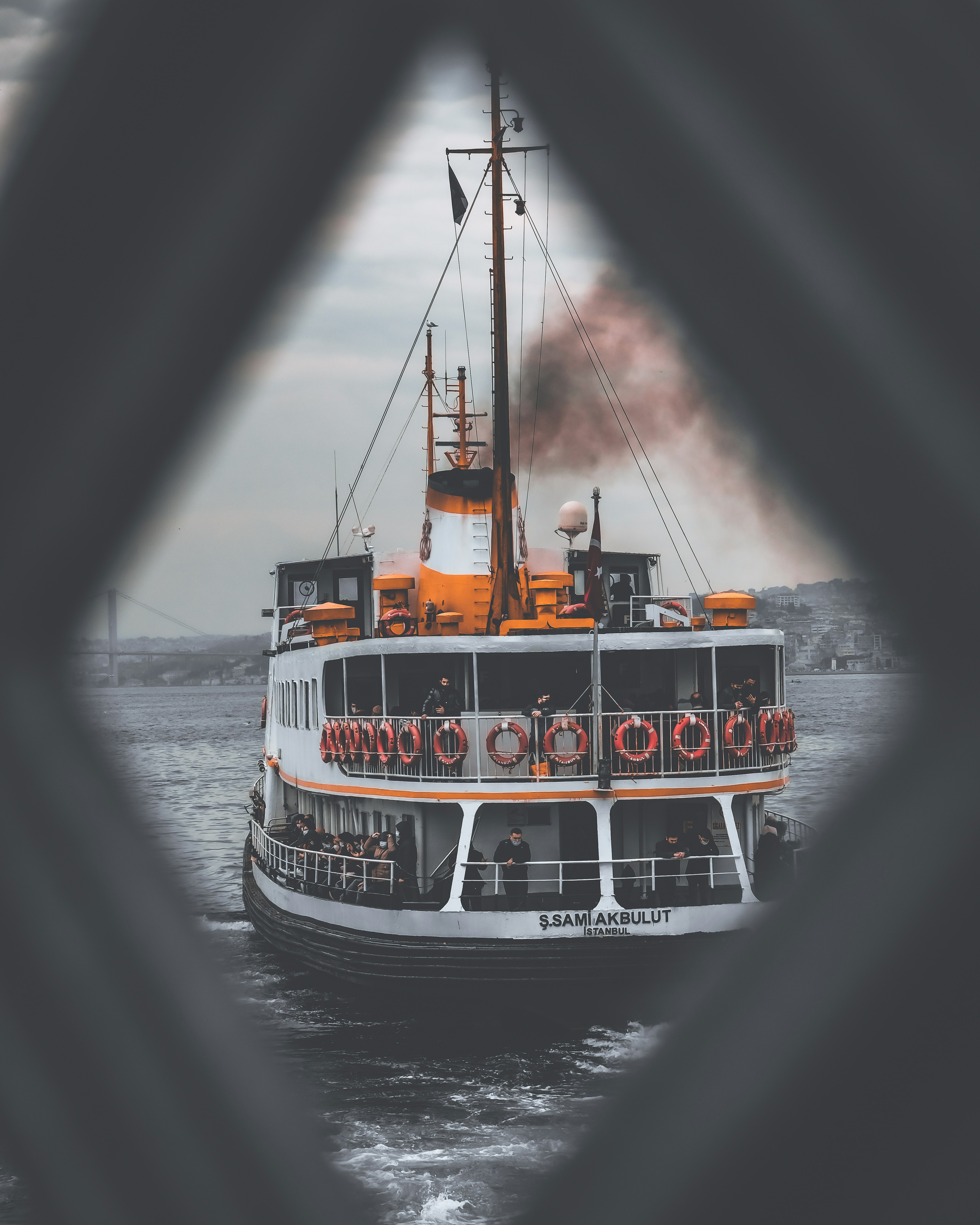 Through the Diamond Frame: Smoky Harbor Ferry in Orange Glow