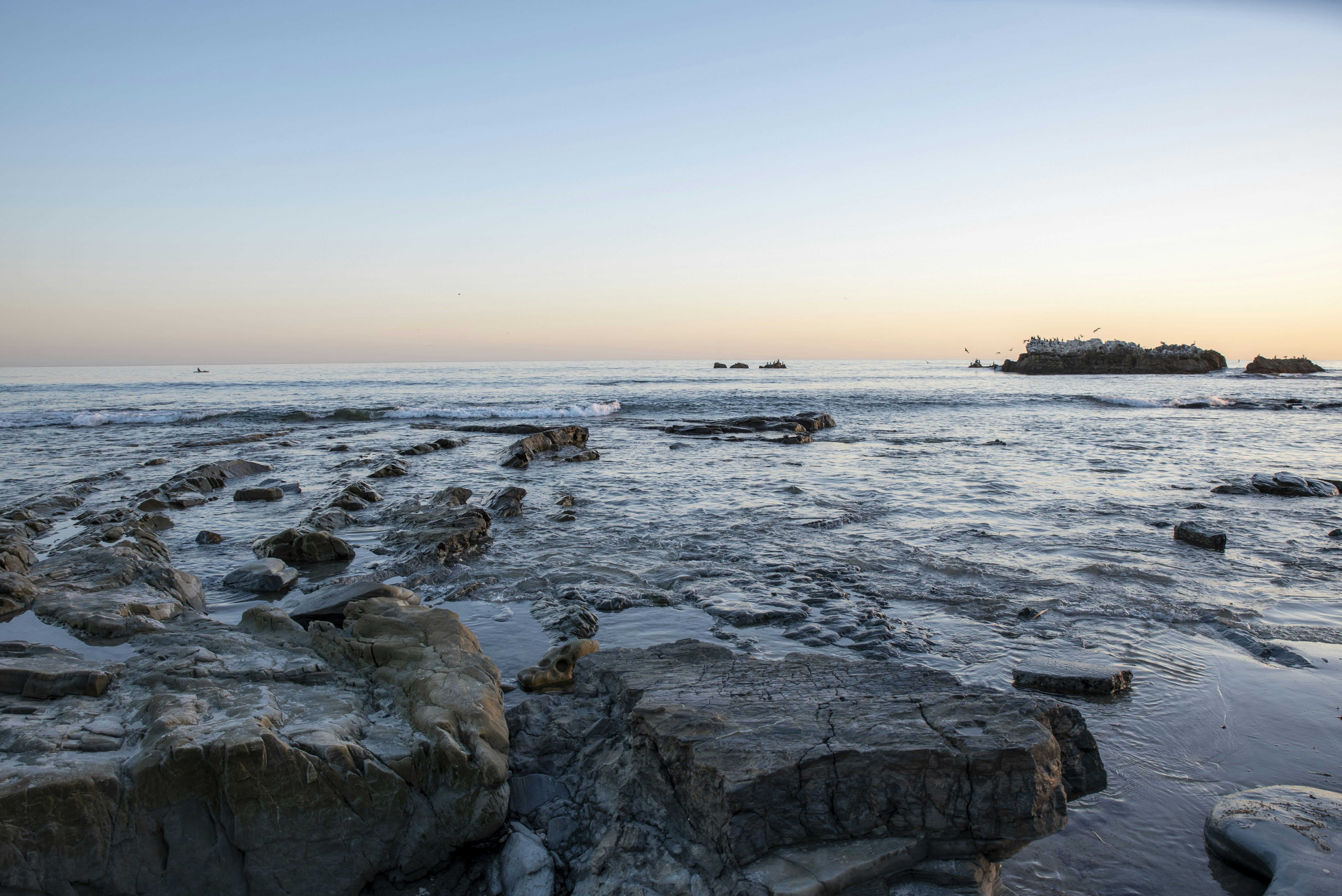 Tide-kissed Rocks at Dusk: Quiet Horizon over a Rocky Shore