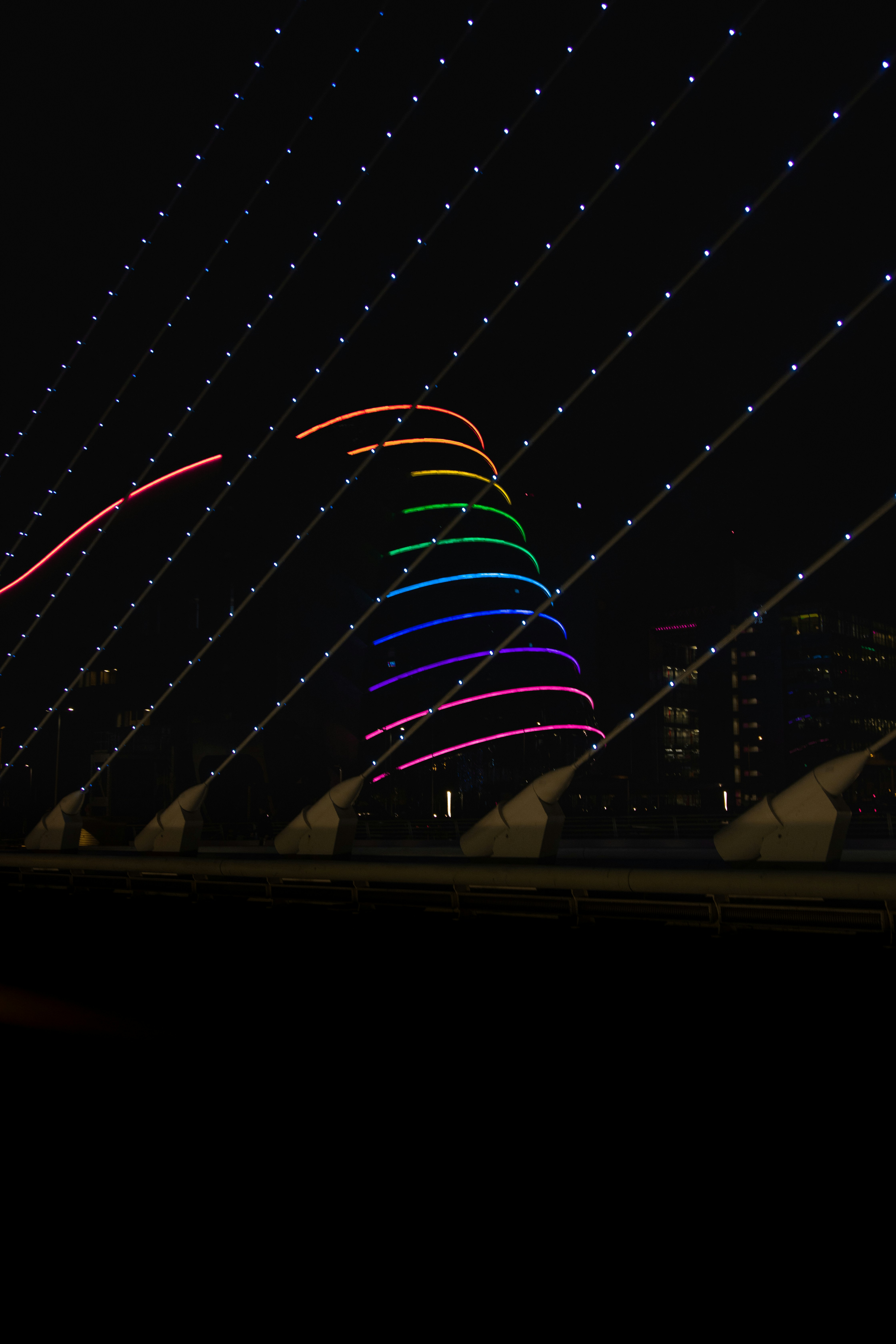 Colorful lights spiral upward against a dark skyline, creating a vibrant visual melody. This illustration captures the essence of urban nightlife.