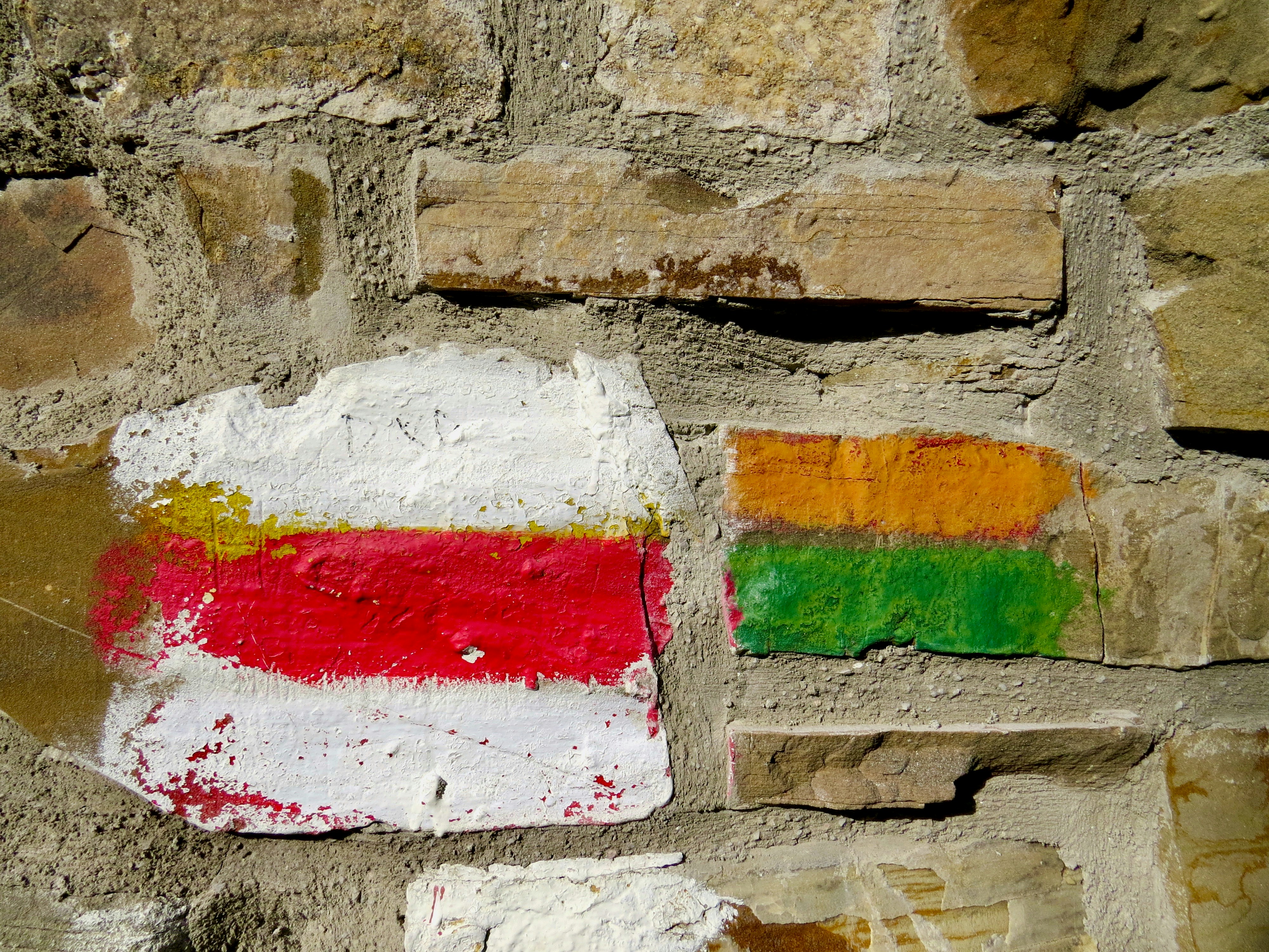 Patchwork on Weathered Stone: Red-White Patch Meets Orange-Green Blocks