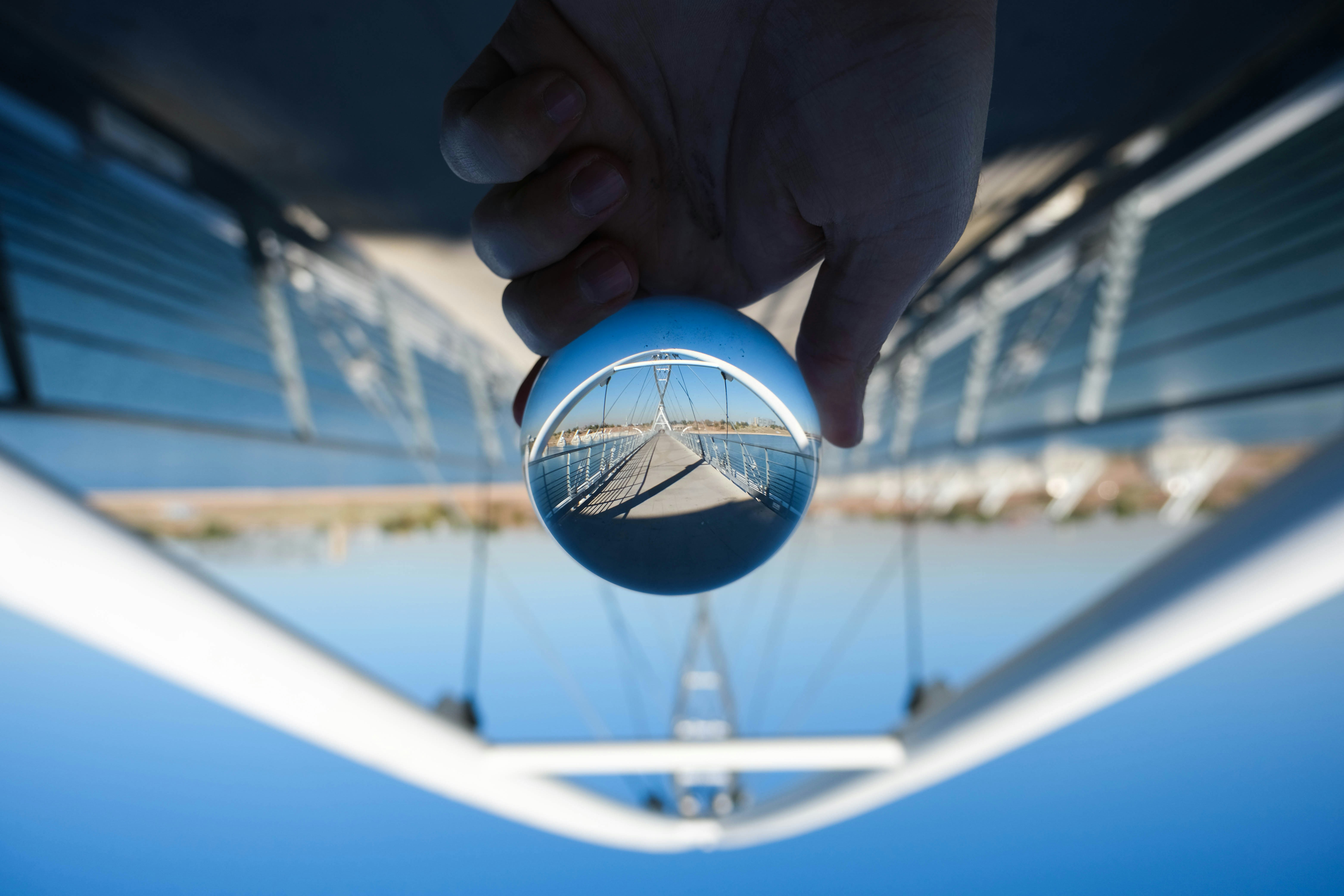 Blue Sphere on a Rail: A Ground-Level Lens Reflects the Bridge