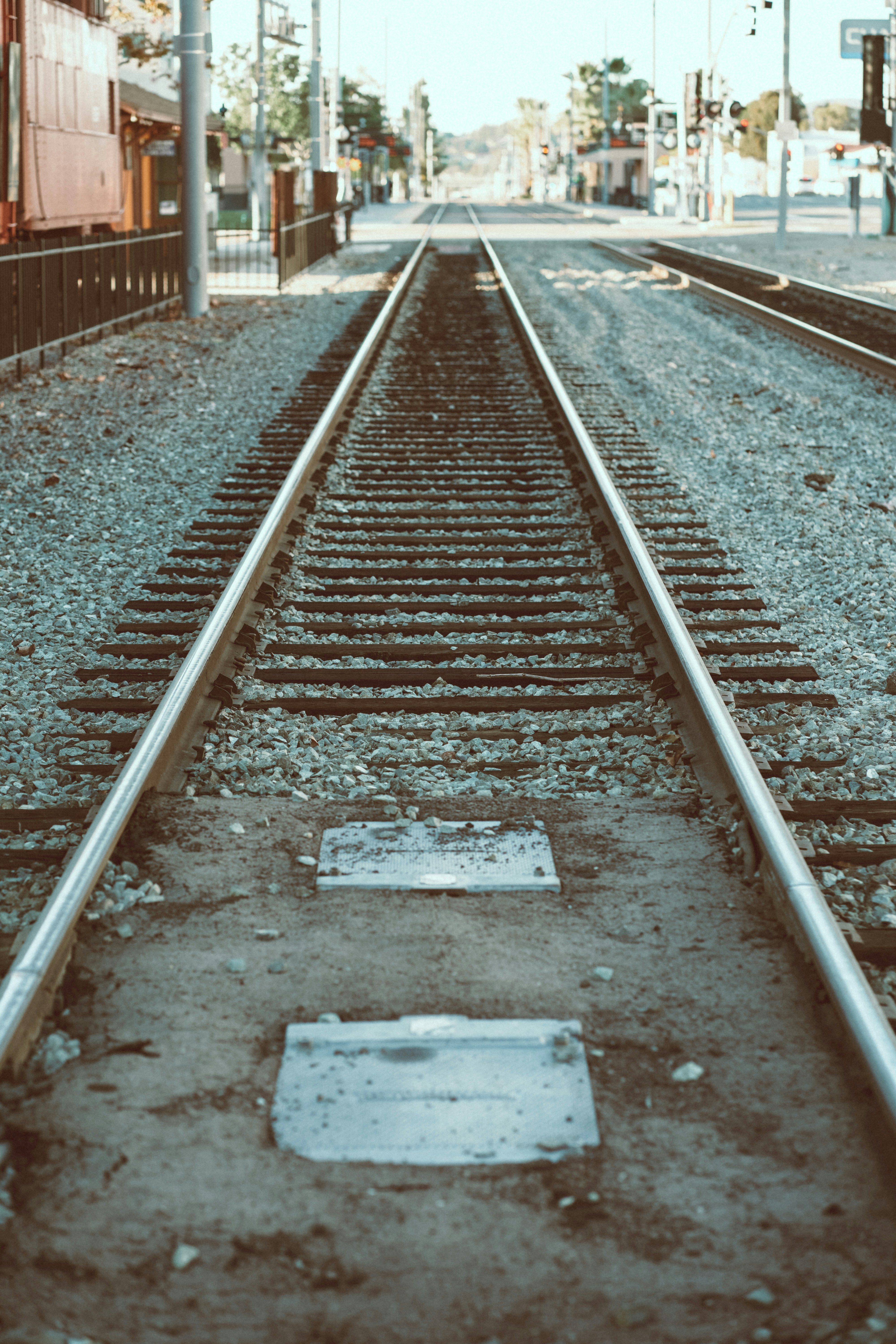 Railroad tracks stretching into the distance, flanked by gravel and signs of wear. The scene evokes a sense of nostalgia and the passage of time.