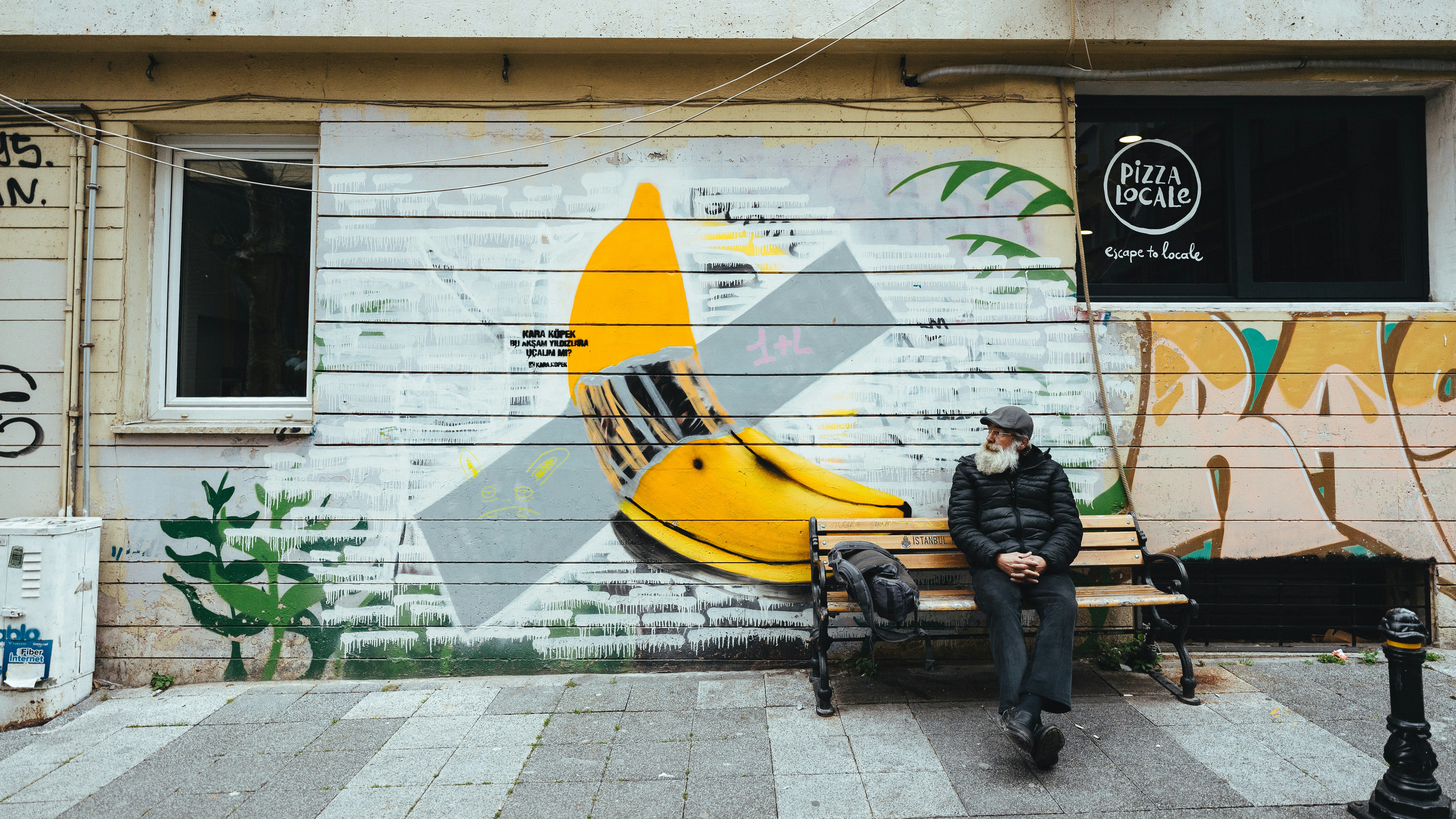 A Quiet Pause beneath a Surreal Banana Mural