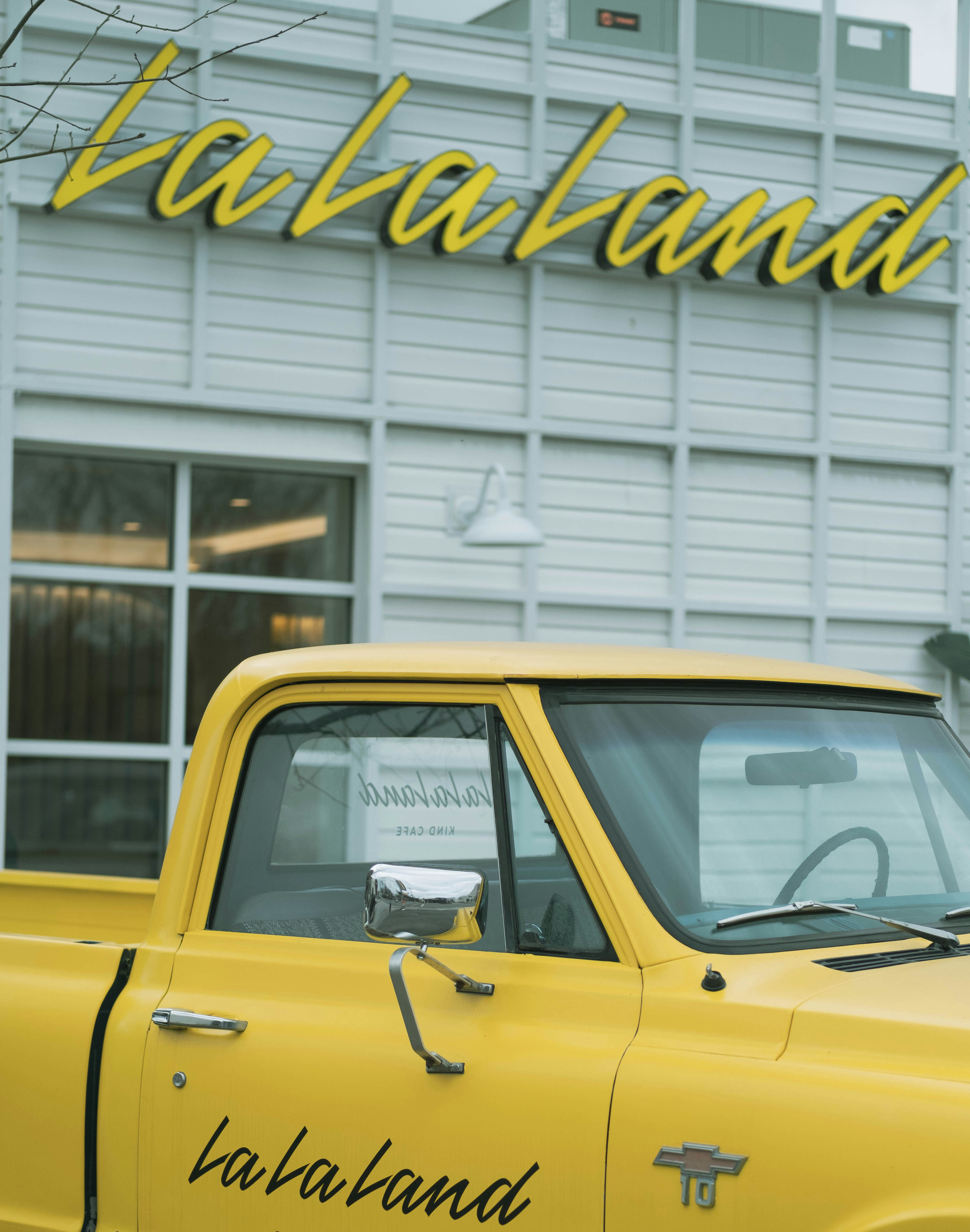Sunlit Vintage Pickup Framed by La La Land Sign