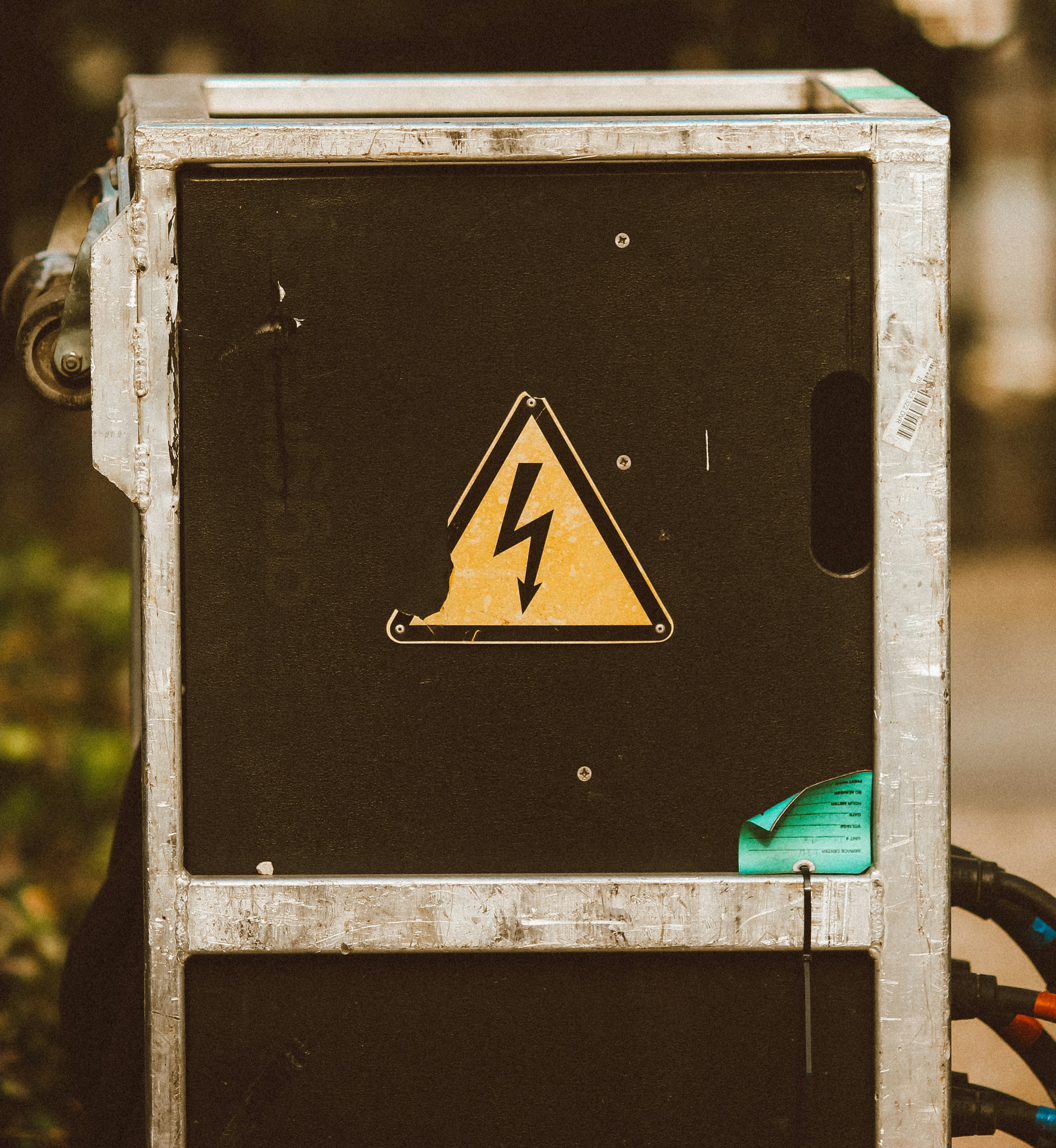 Weathered High-Voltage Cabinet with Bold Warning Triangle