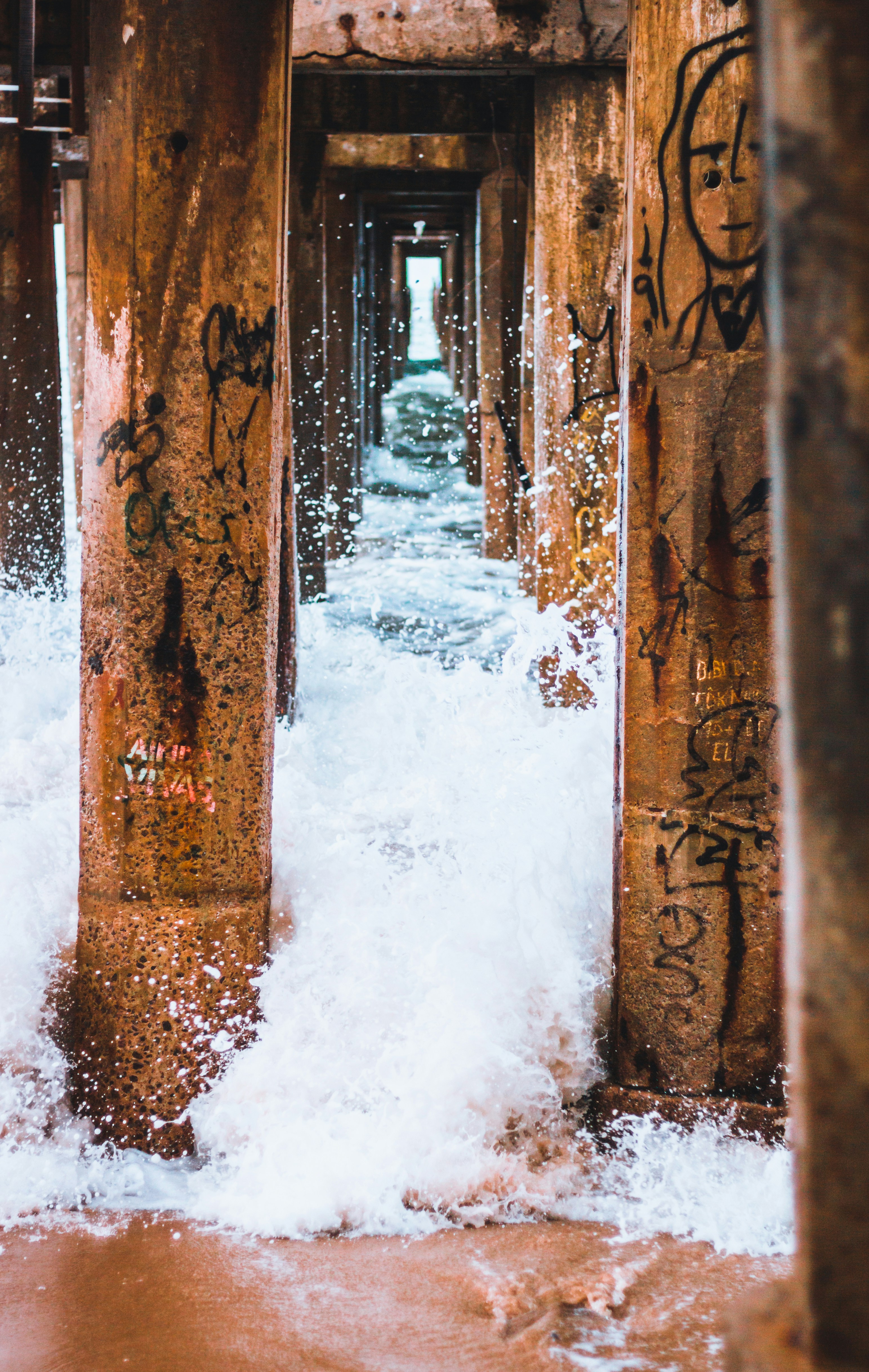 Sea-Foam Corridor: Graffiti, Rust, and Light Under the Pier