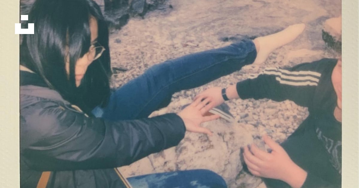 검은 재킷과 파란색 데님 청바지를 입은 여자가 물가 근처 바위에 앉아 있다 사진 Unsplash의 무료 타란토 이미지
