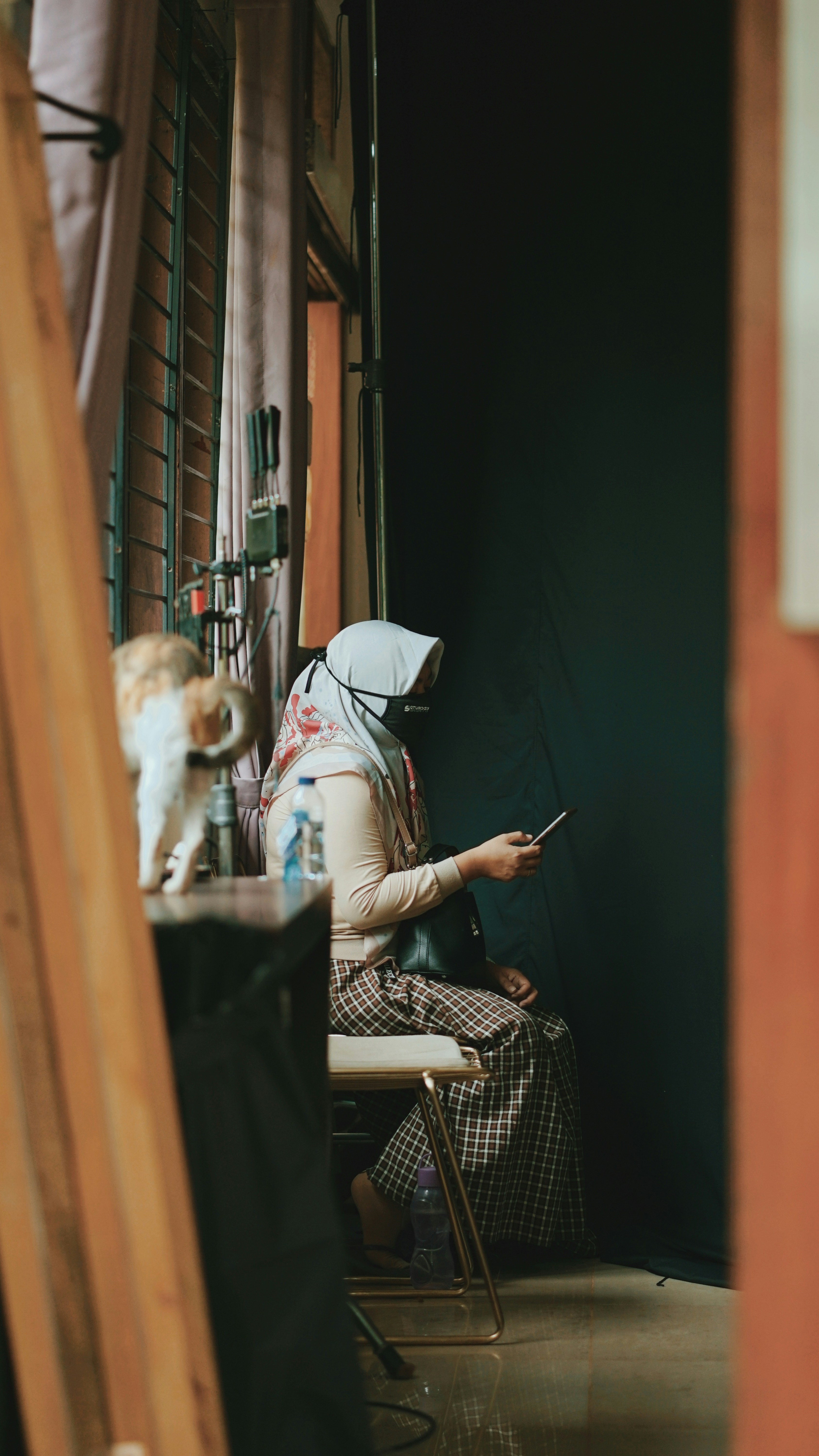 Woman in black and white polka dot dress sitting on chair beside white ...