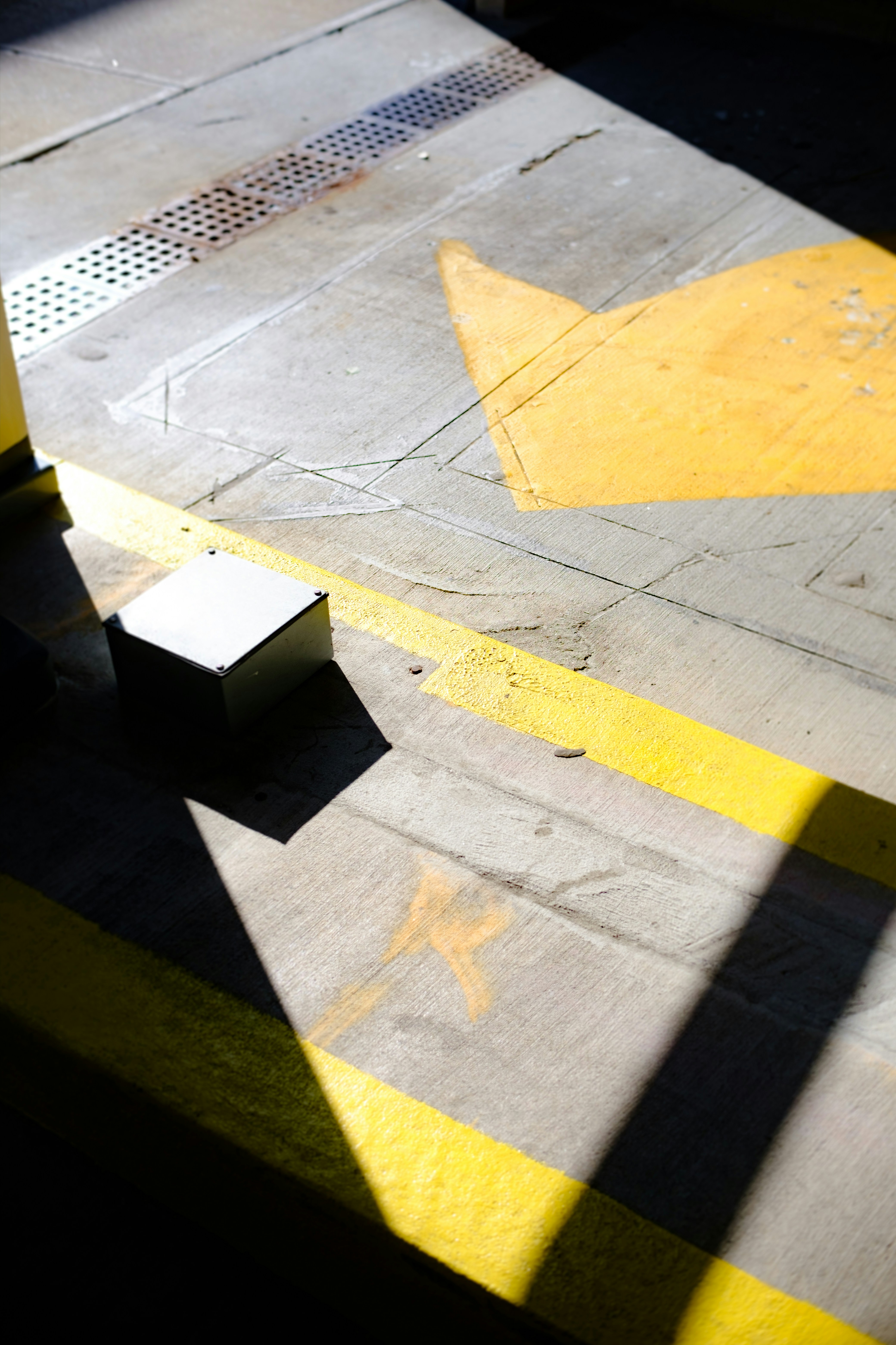 Shadowed Stairway with Yellow Arrow and Sunlit Edge