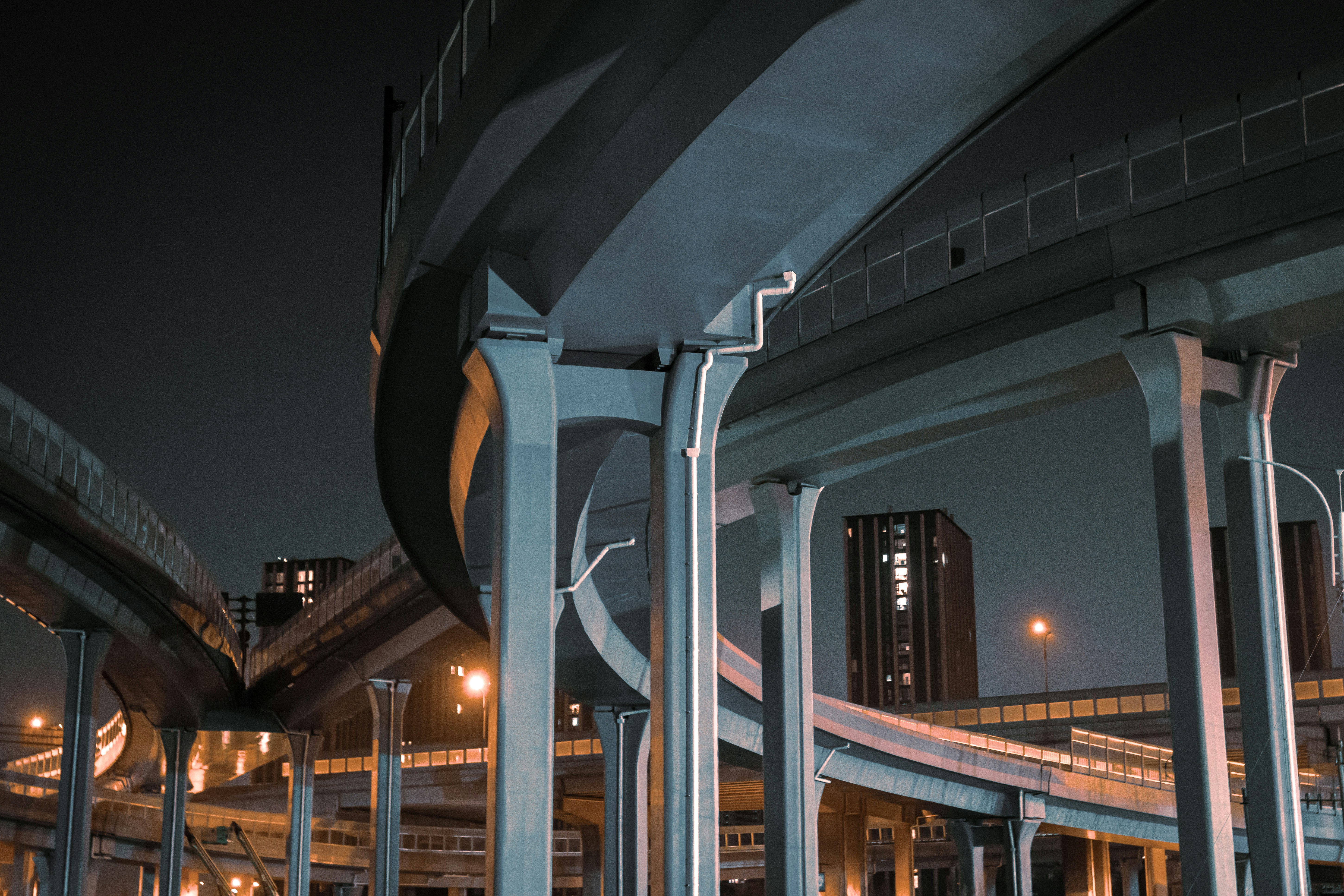 Intricate overpasses intertwine under city lights, showcasing modern infrastructure against a night sky.