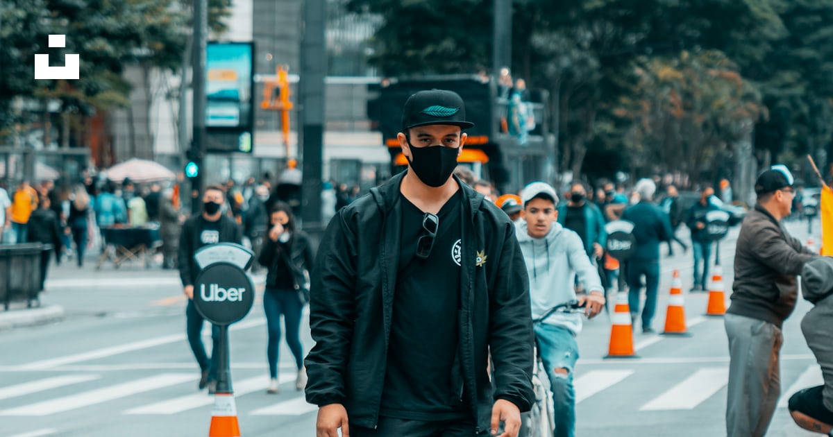 검은 재킷과 검은 모자를 쓴 남자가 회색 콘크리트 도로에서 검은 킥 스쿠터를 타고 사진 Unsplash의 무료 아베니다