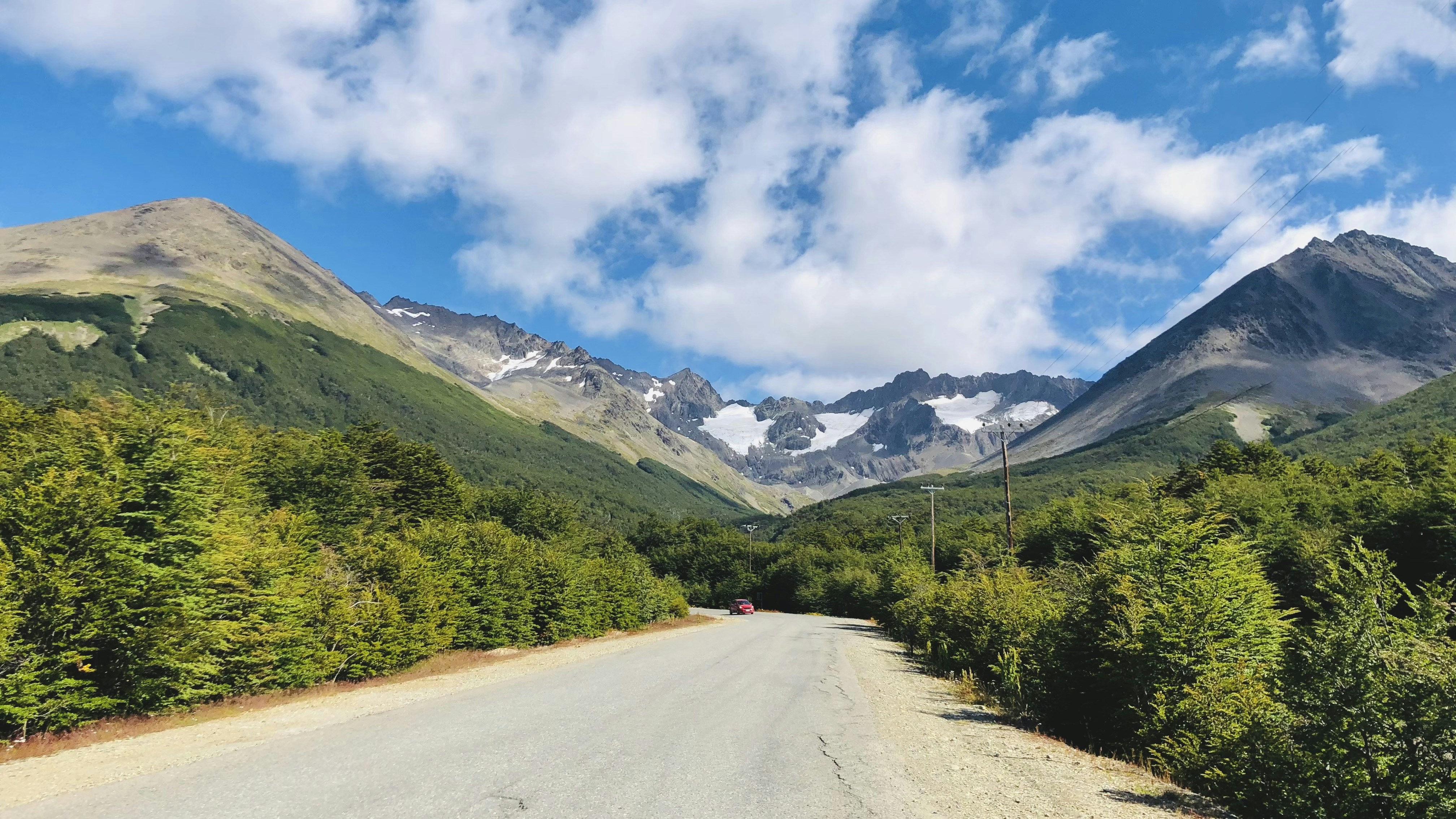 Road Through the Green Spine Toward Snow-Dusted Peaks