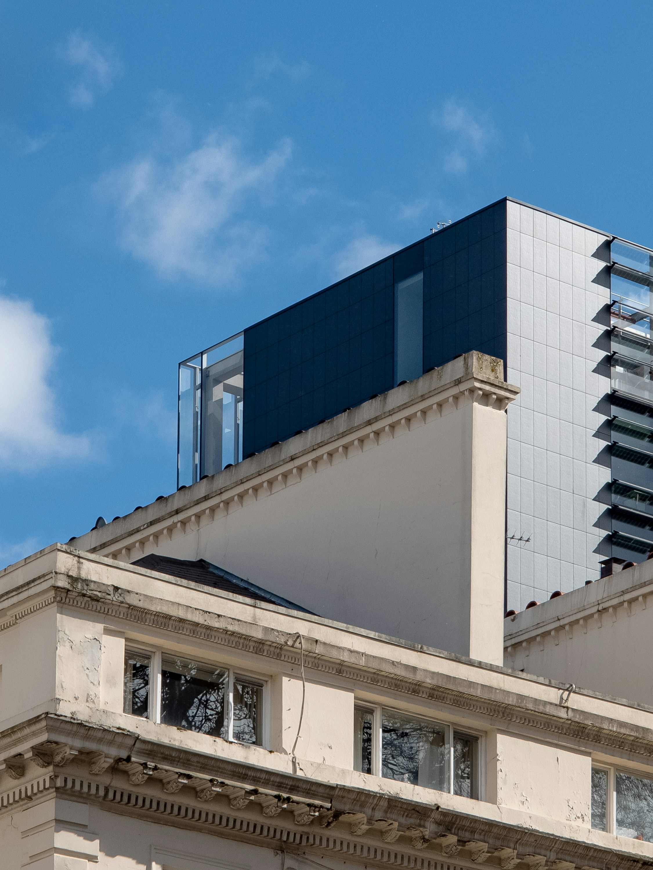 Skyline of Modern Top Floor: Glass Balcony Over Classical Facade