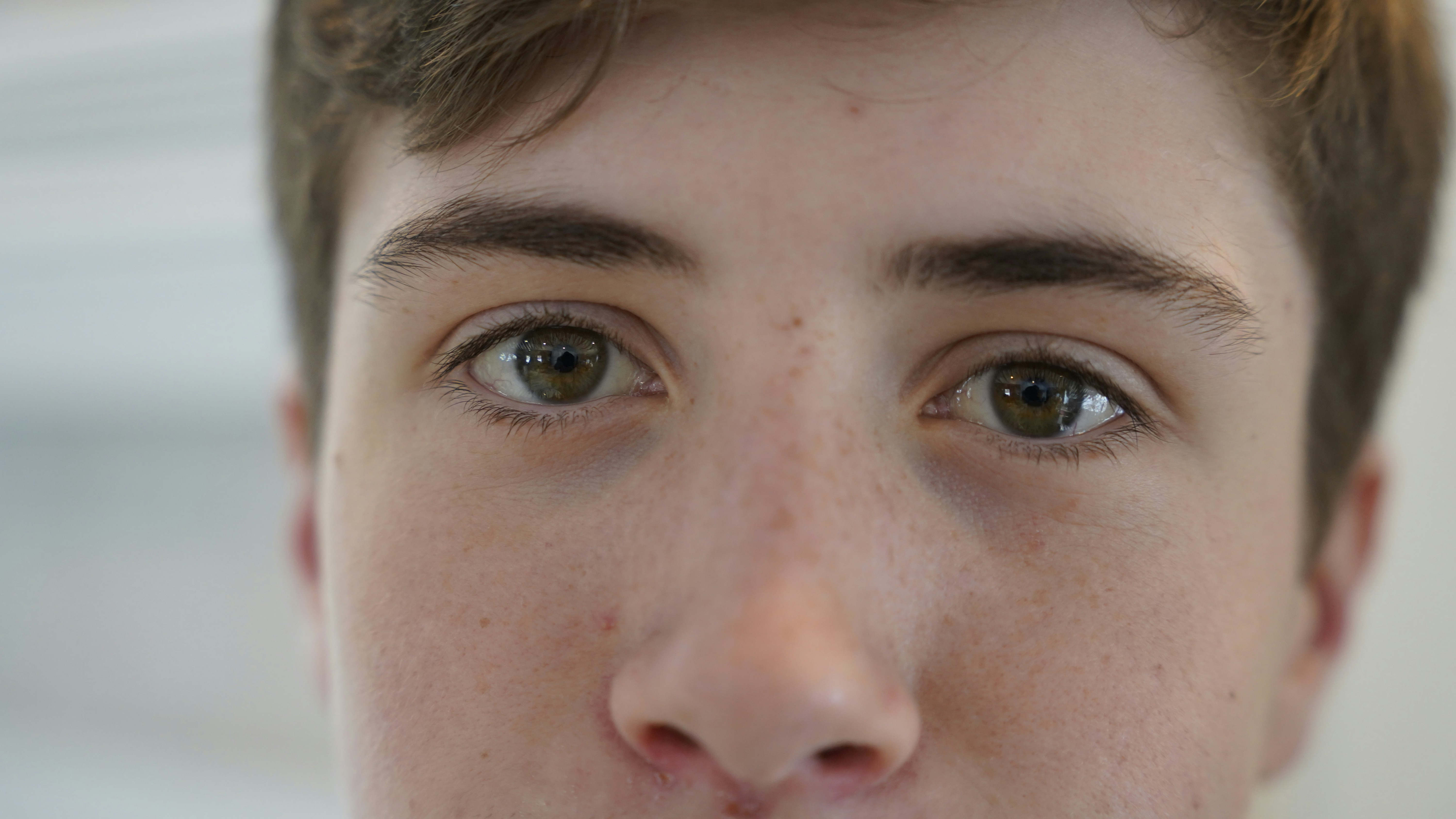 Close-up of a young person's eyes, revealing intricate details and expressions. The focus highlights the natural beauty and depth of the gaze.