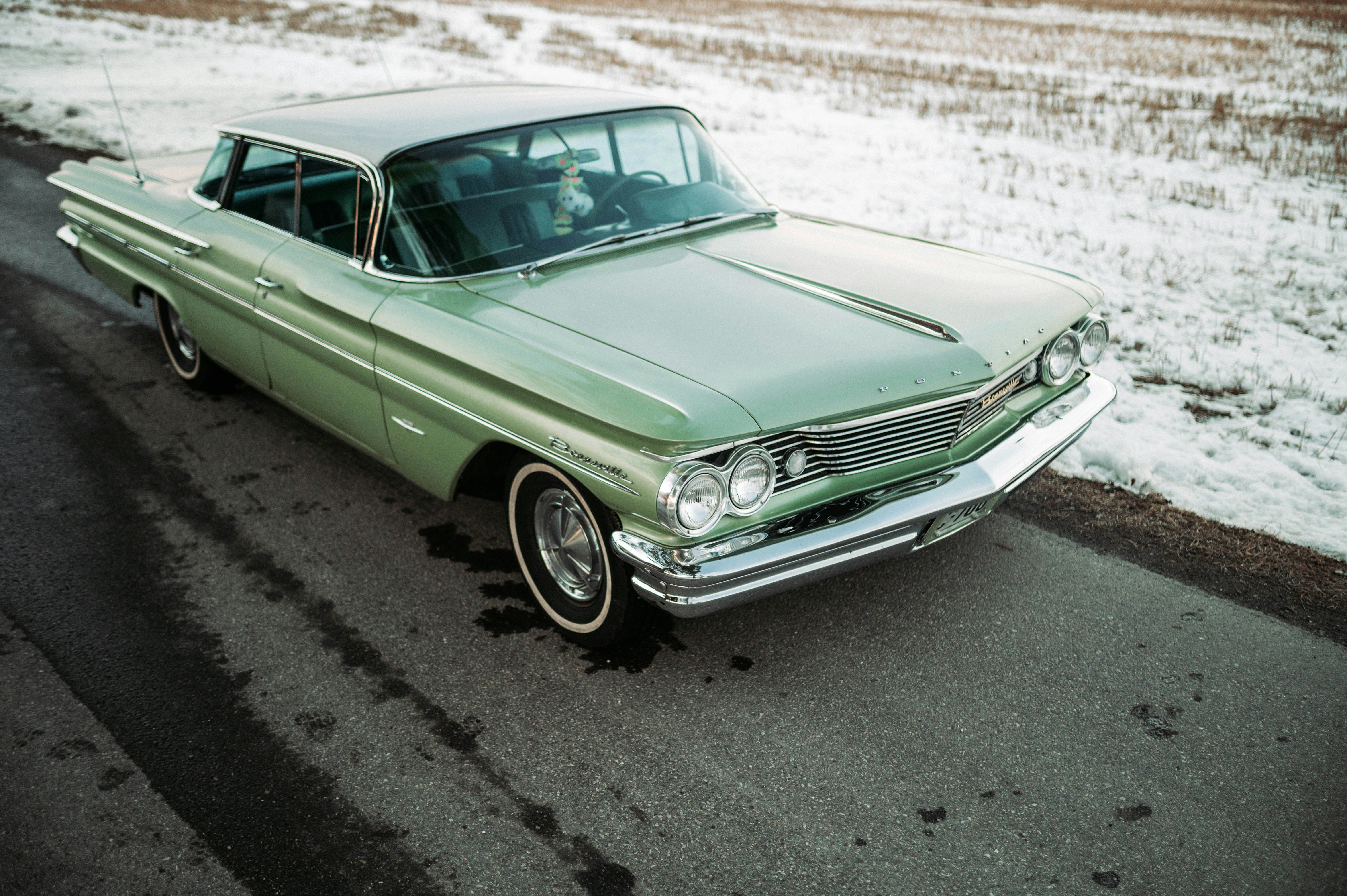 A 1959 Pontiac Bonneville | white classic car on road during daytime