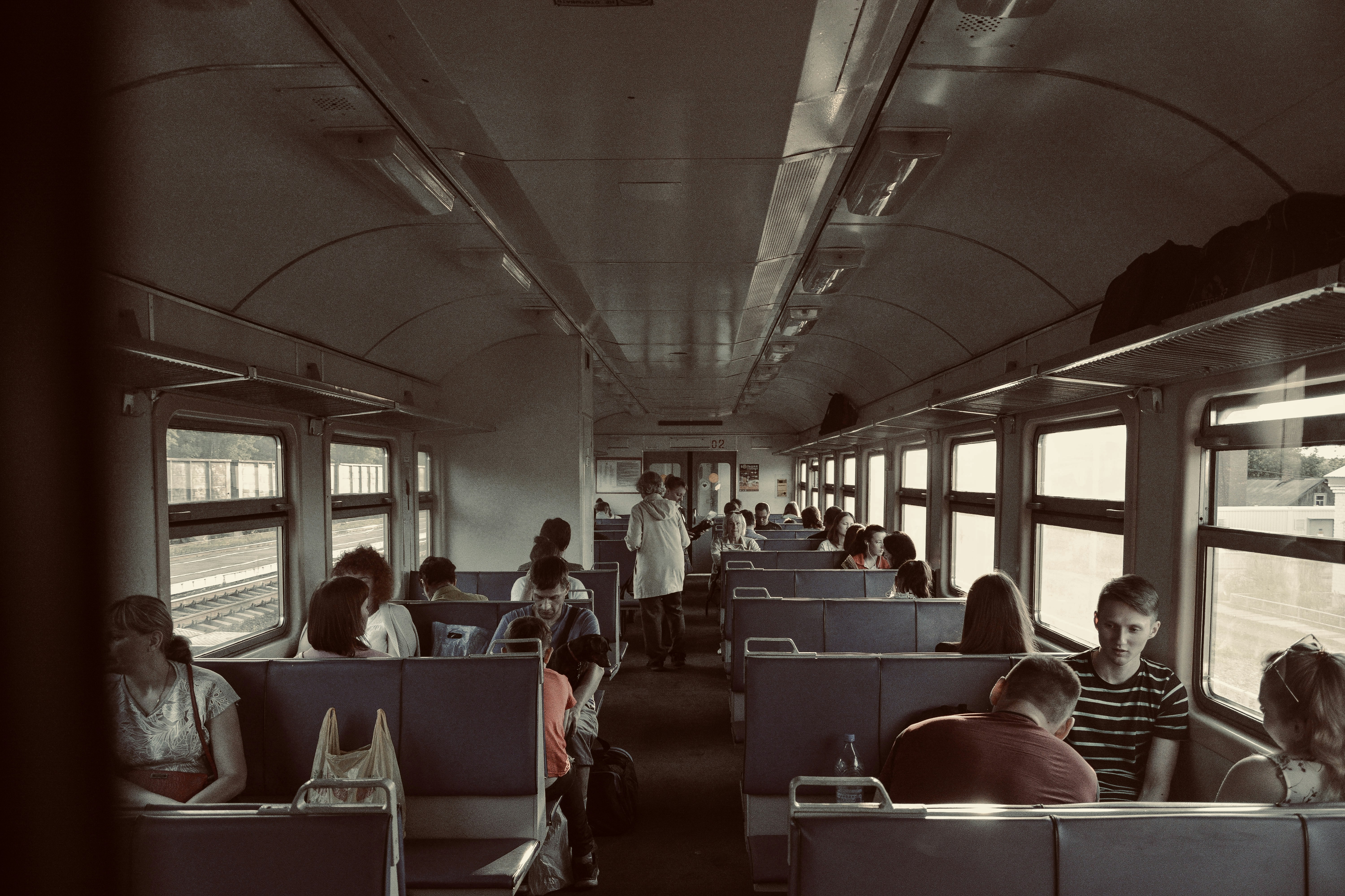 Interior view of a vintage train car filled with passengers, showcasing the nostalgic atmosphere and design of railway travel.