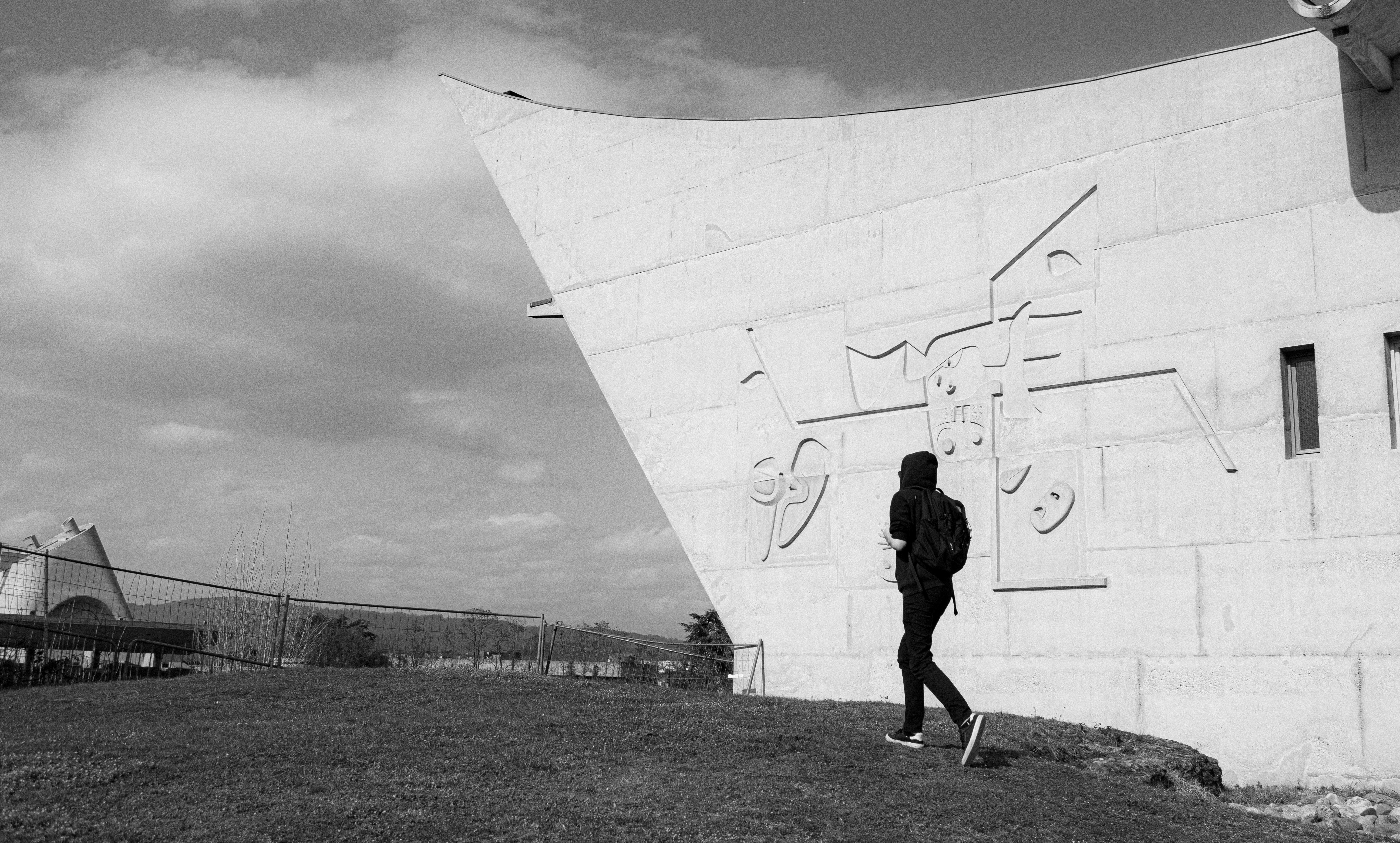 Lone Wanderer Traces Lines of a Concrete Monolith