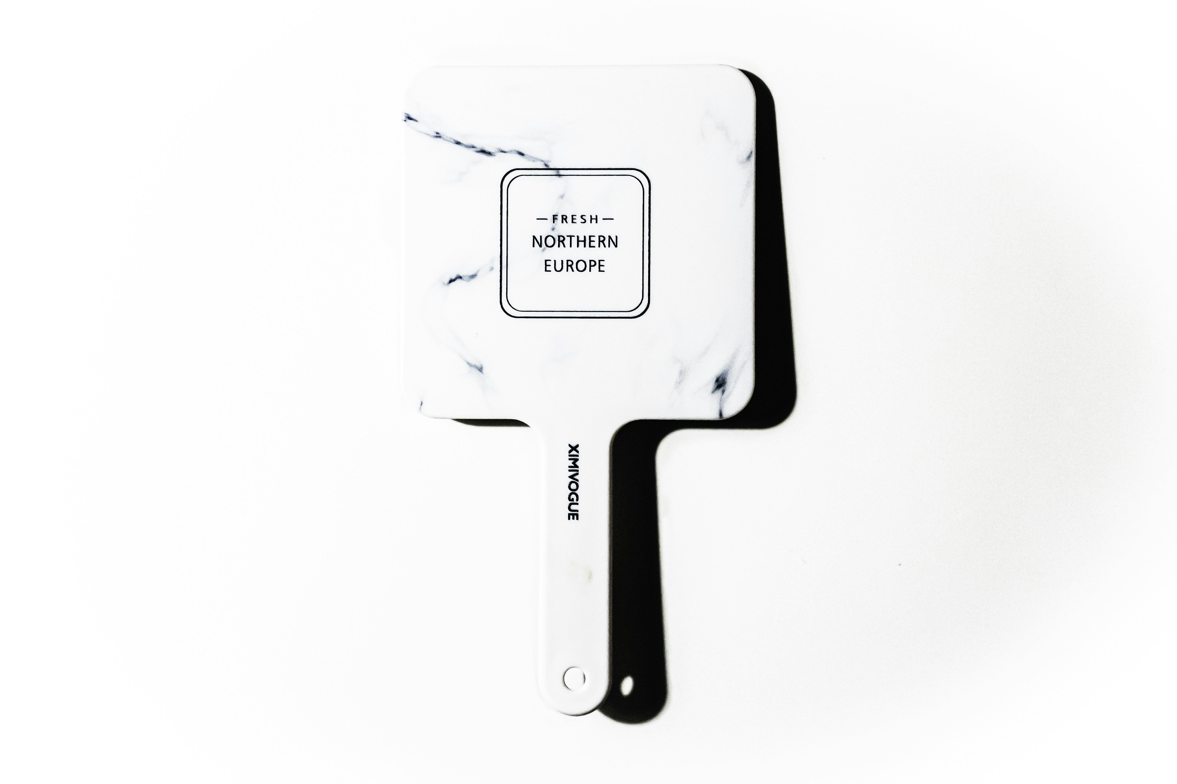 Minimalist product shot of a marble-pattern handheld device bearing a square 'NORTHERN EUROPE' label on a stark white background.