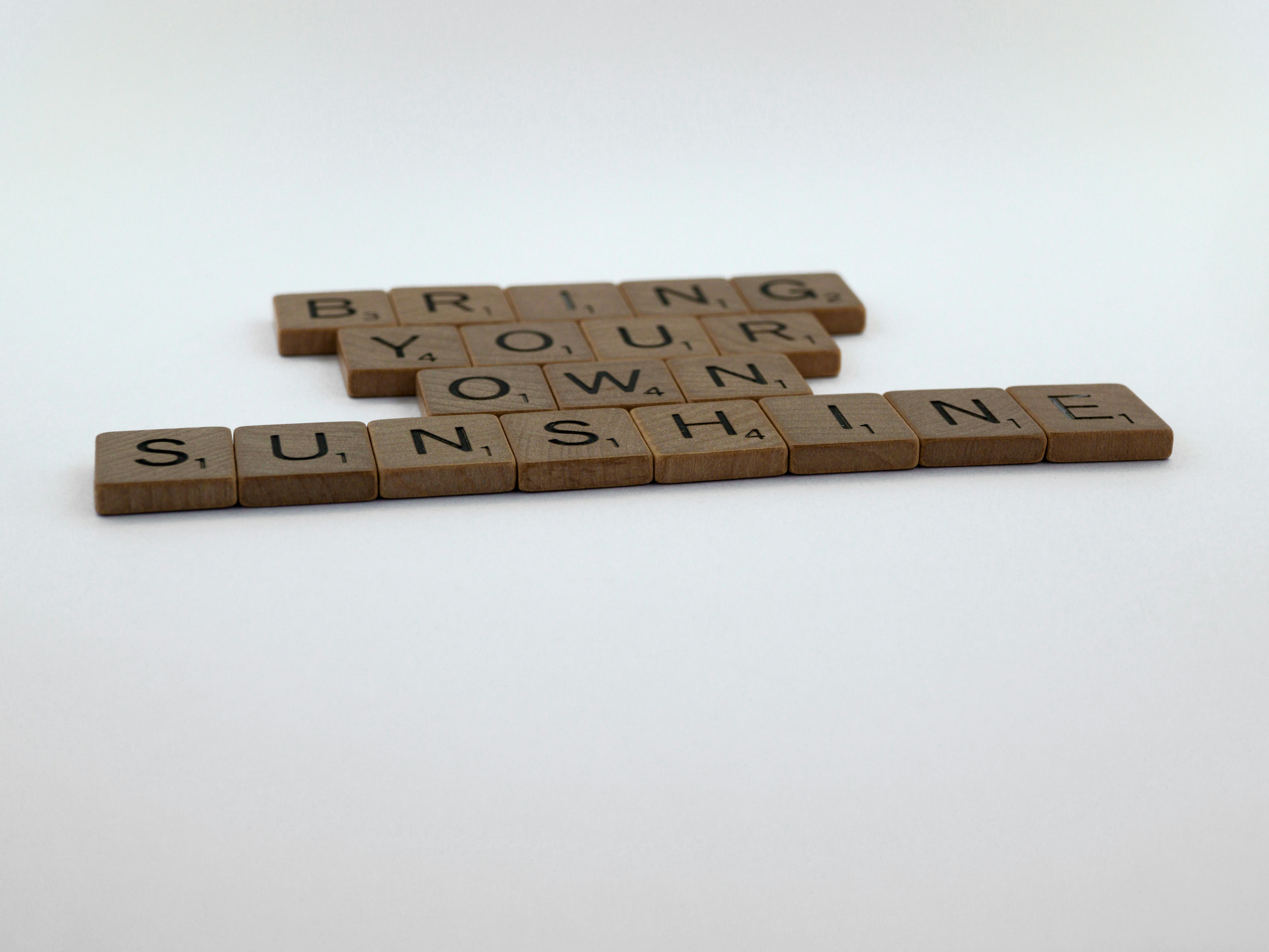 Wordplay in Wood: Sunny Scrabble of Letters on a Clean White Stage