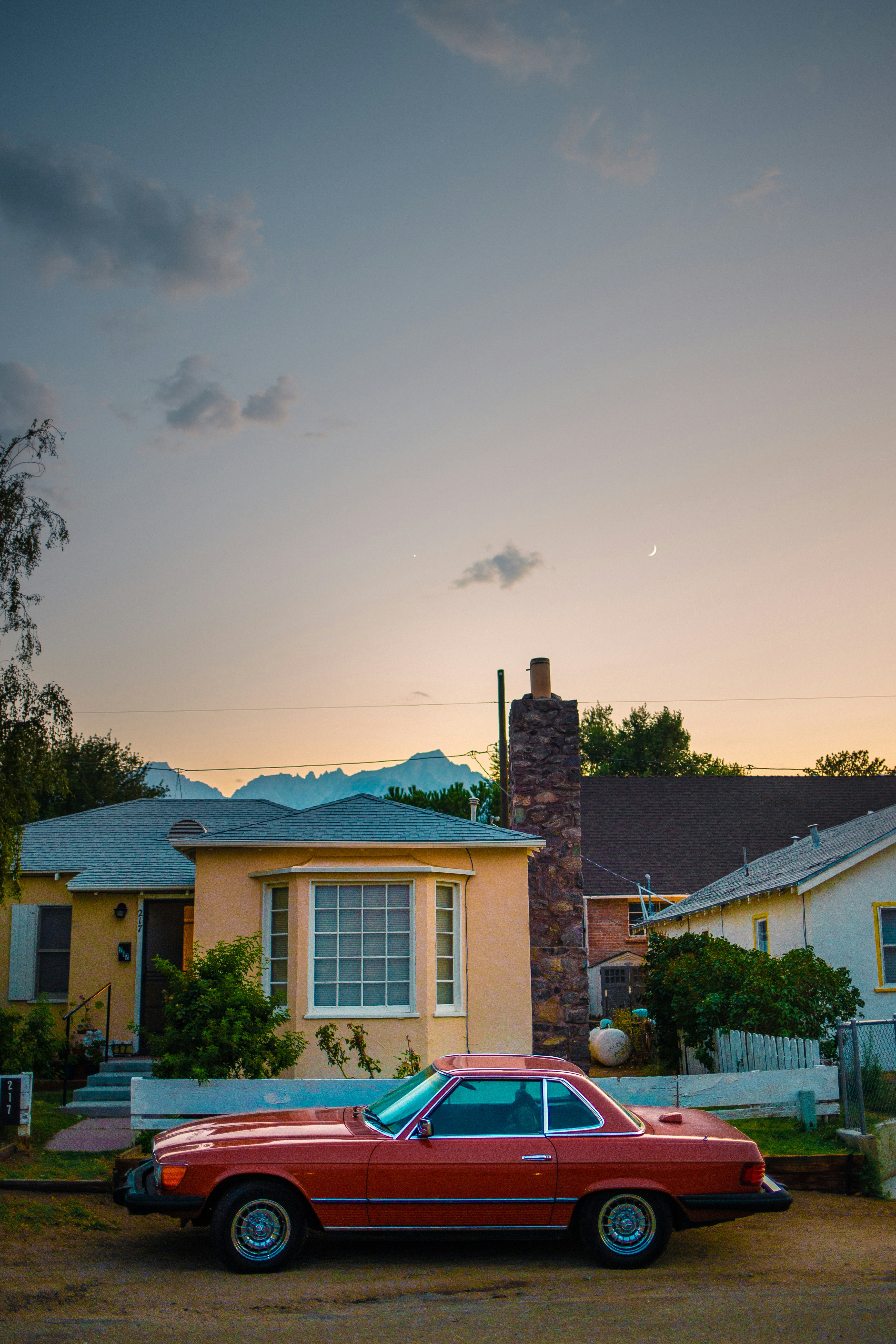 Crimson Classic at Dusk: A Vintage Car in a Quiet Suburban Scene
