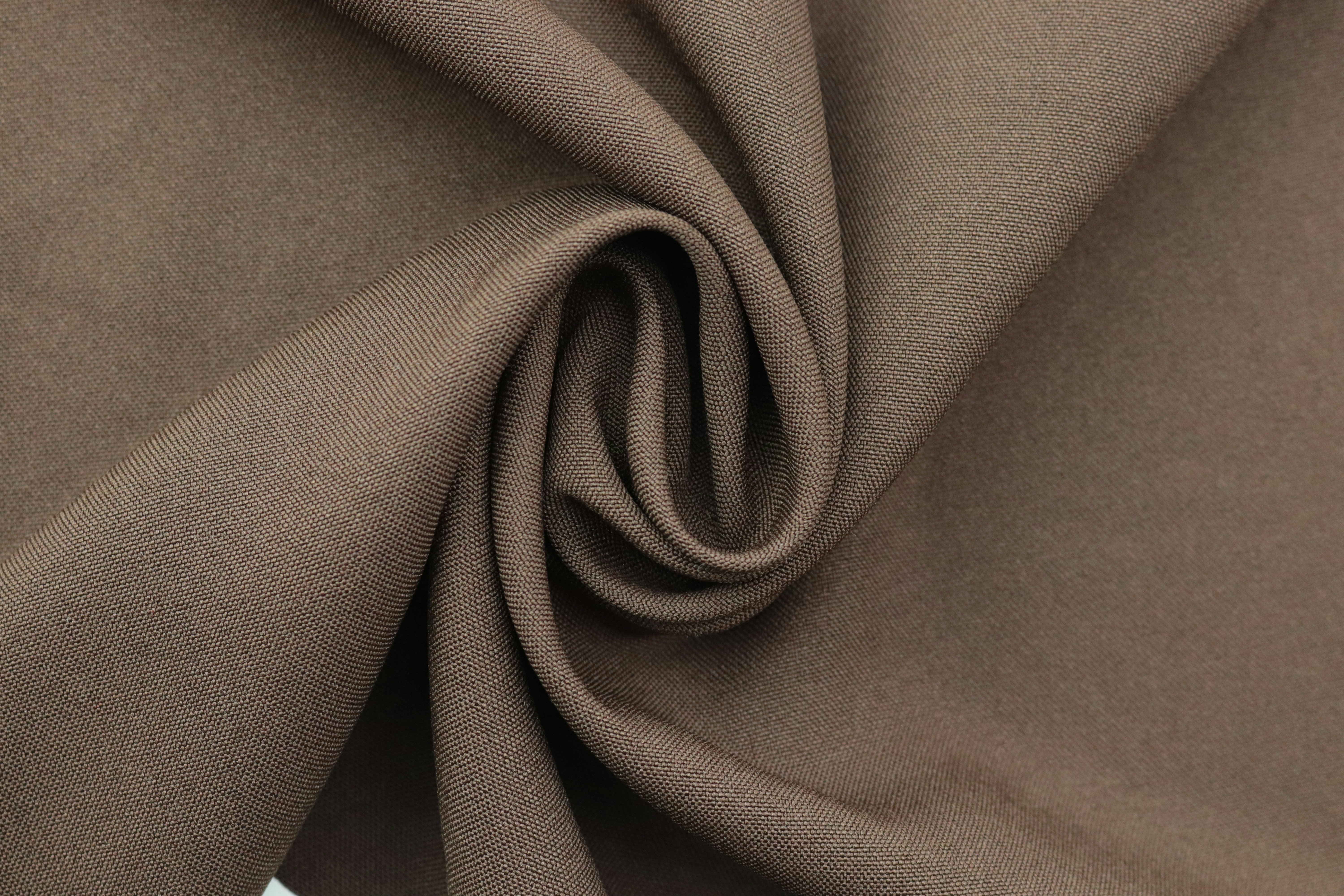 Close-up of a brown fabric elegantly twisted, showcasing its texture and depth.