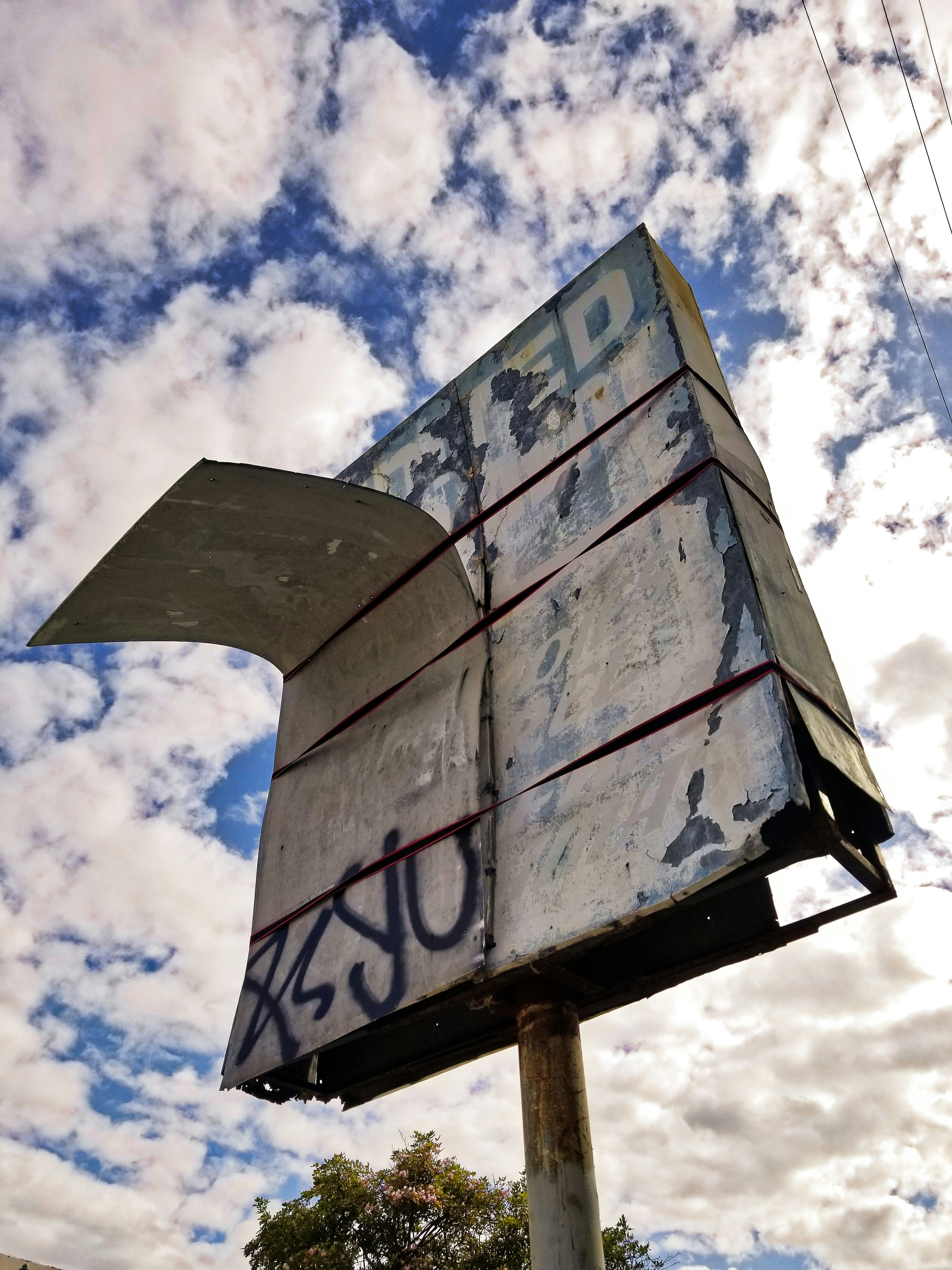 Gray and white wooden signage under blue sky during daytime photo ...
