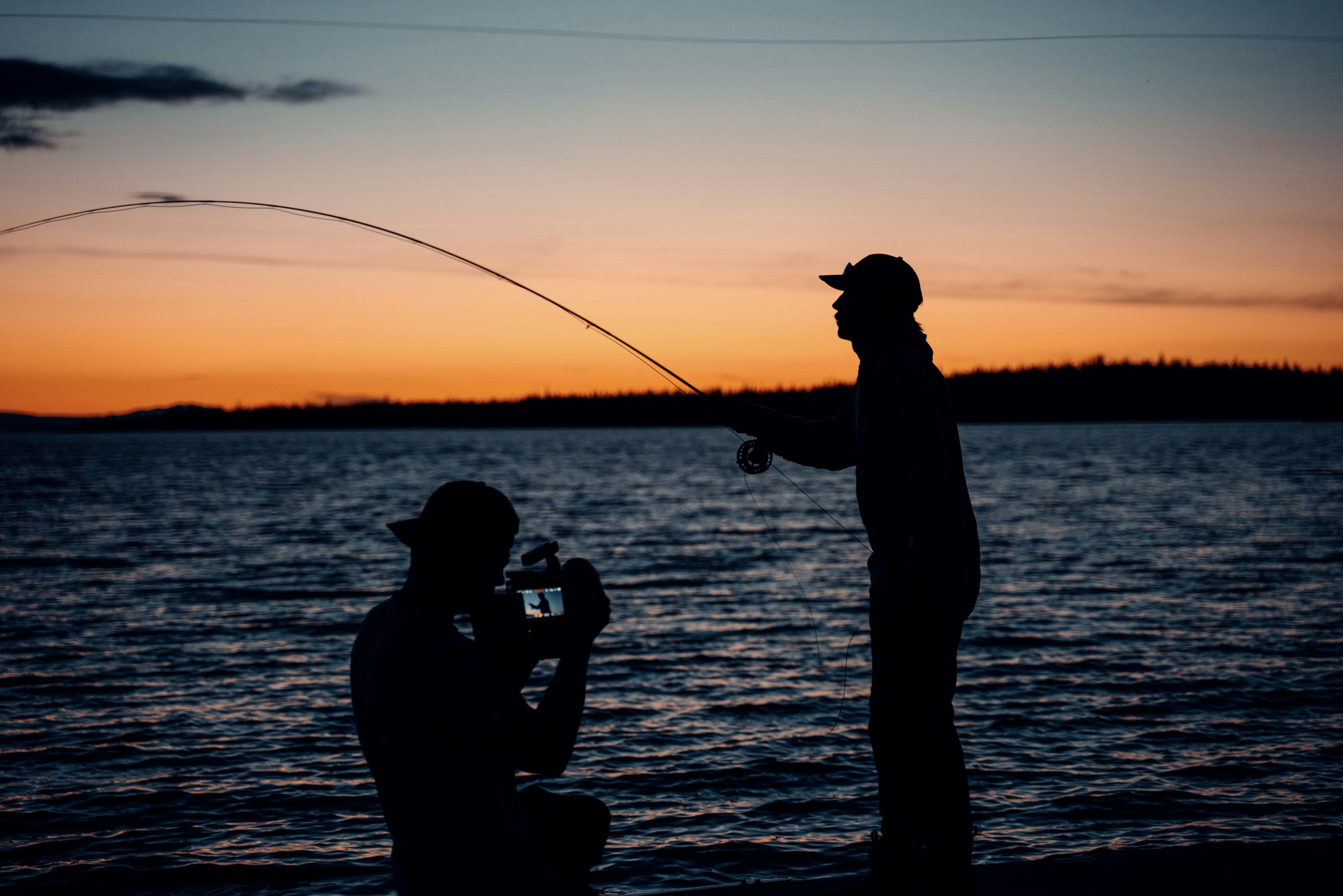 Foto Silueta de 2 personas pescando durante la puesta del sol – Imagen ...