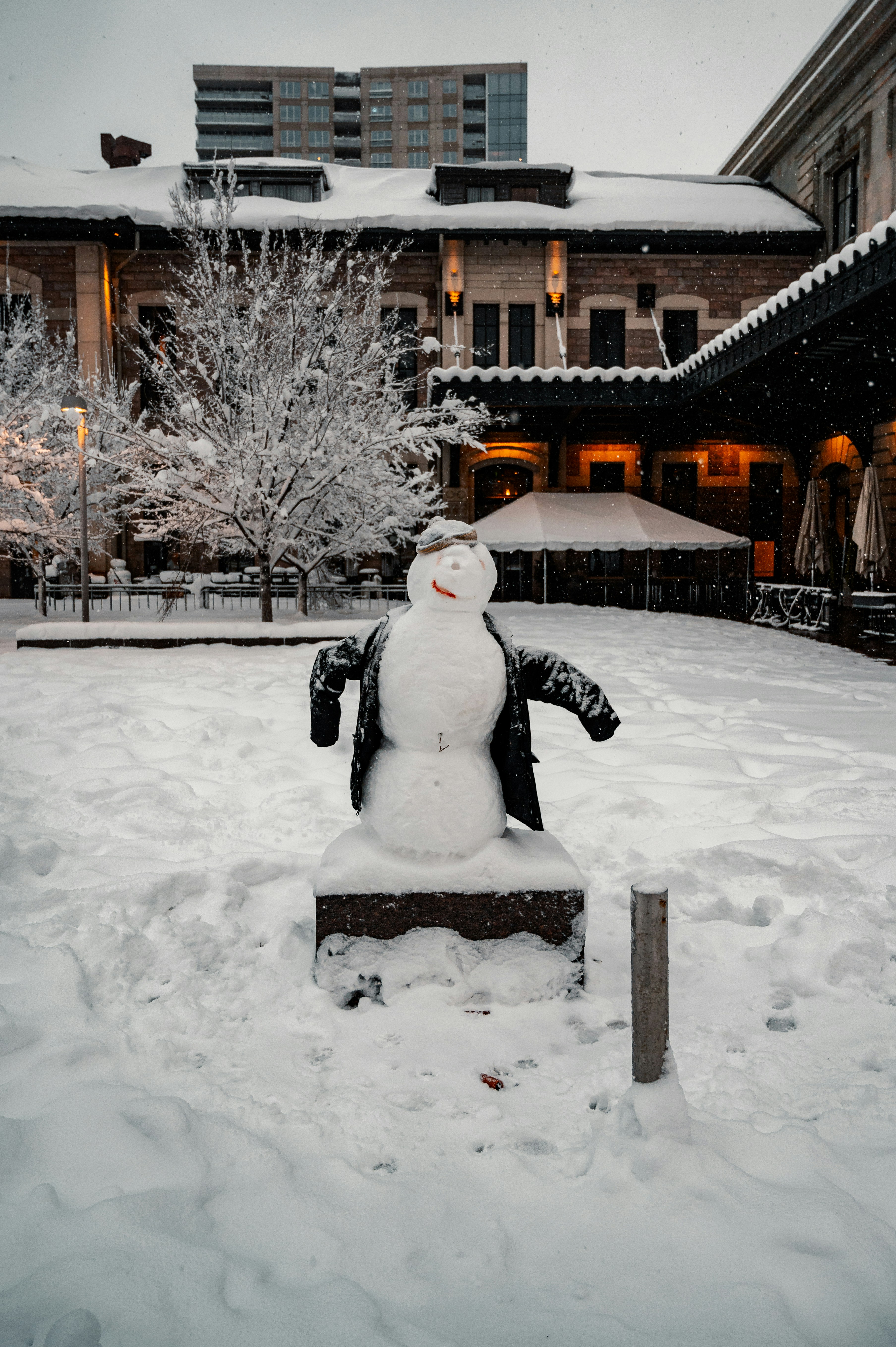Snowman Sentinel in a Snow-Blanketed Courtyard Under Amber Lanterns