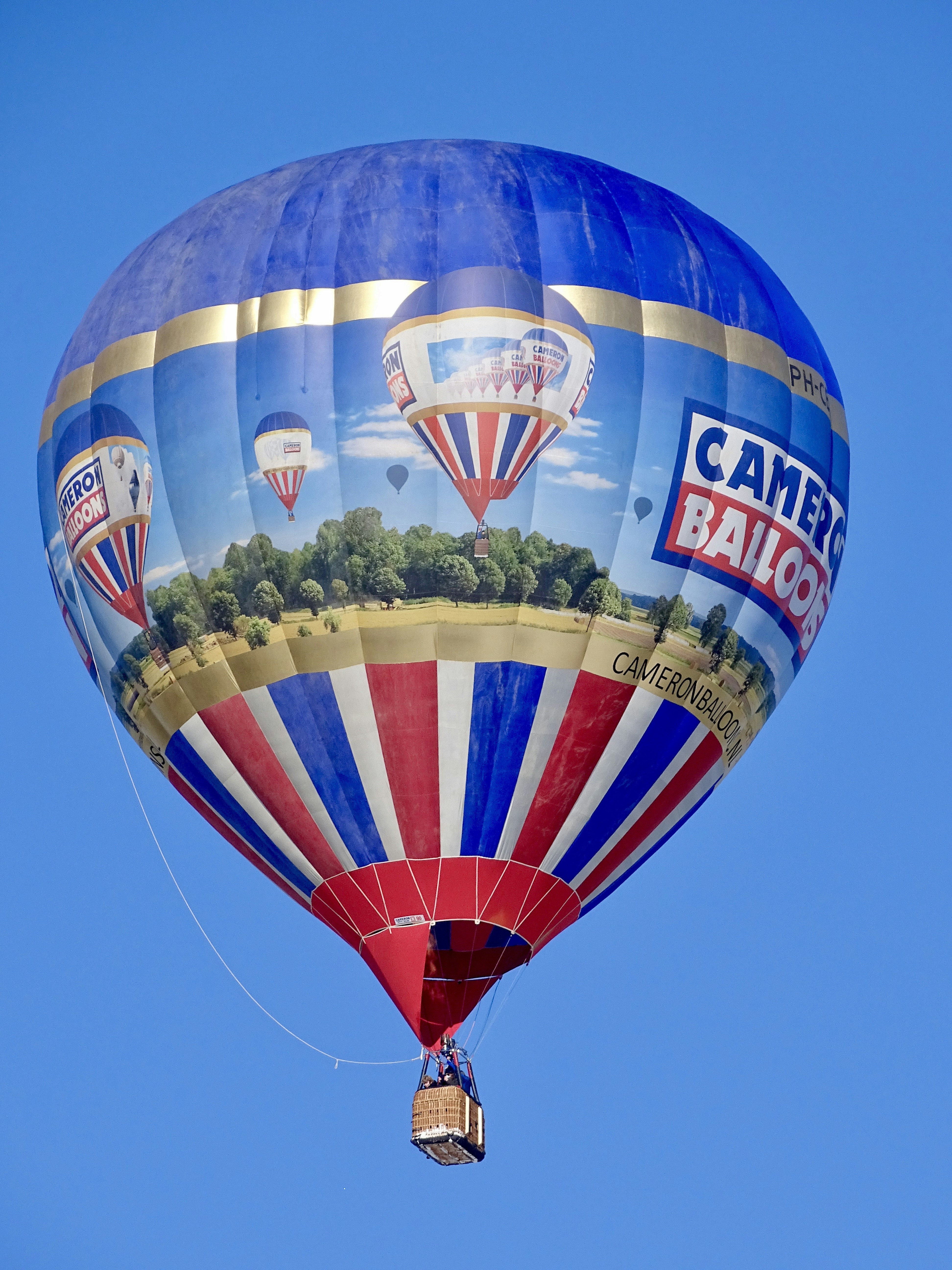 Azure Giant Over Blue: A Striped Hot-Air Balloon in Free Flight