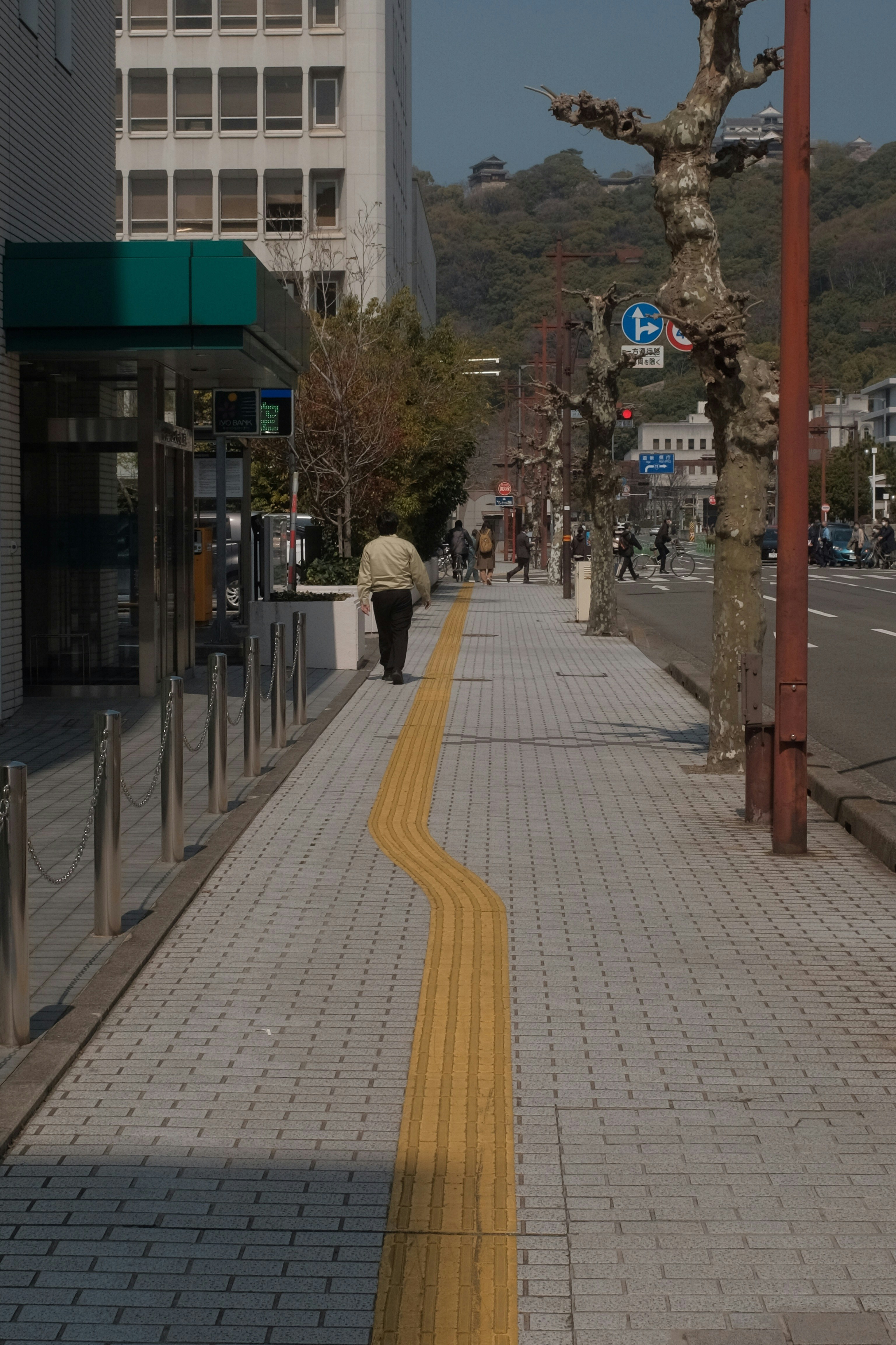 Les personnes qui marchent sur le trottoir pendant la journée ; photo ...