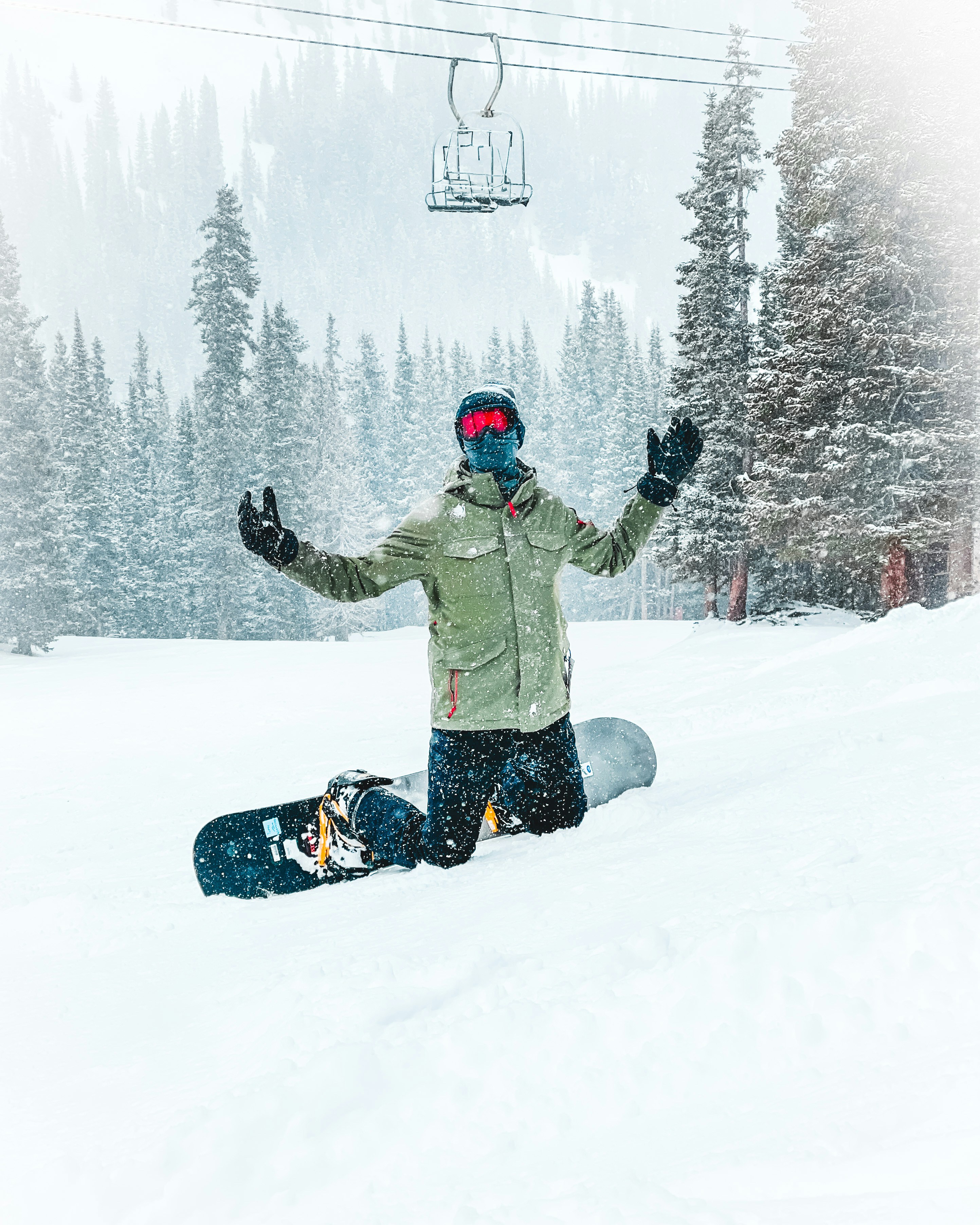 Snowbound Enthusiasm: Rider Raises Snowboard Amid Snowfall