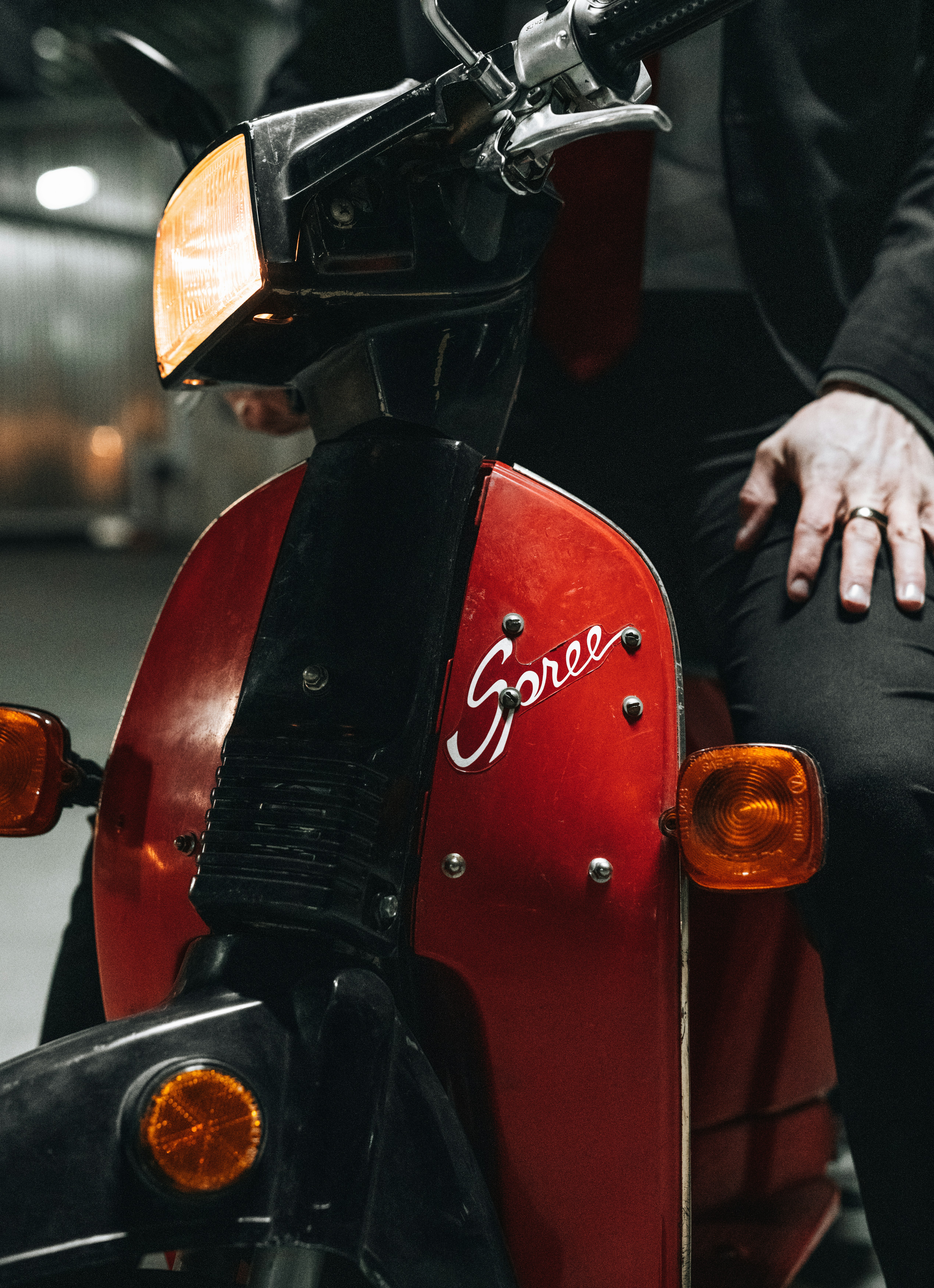 person in black suit riding red motorcycle