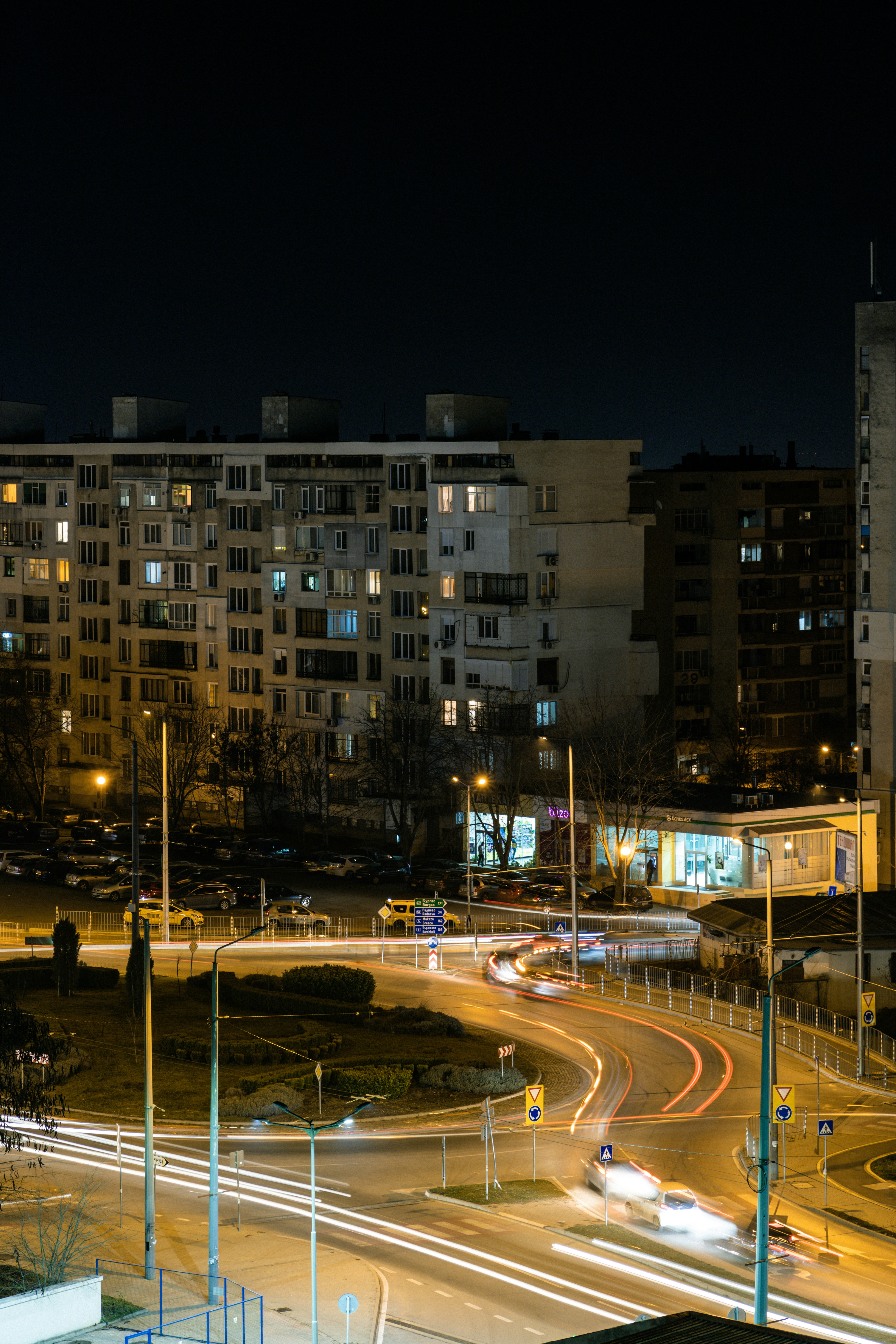 time lapse photography of cars on road near high rise building during night time
