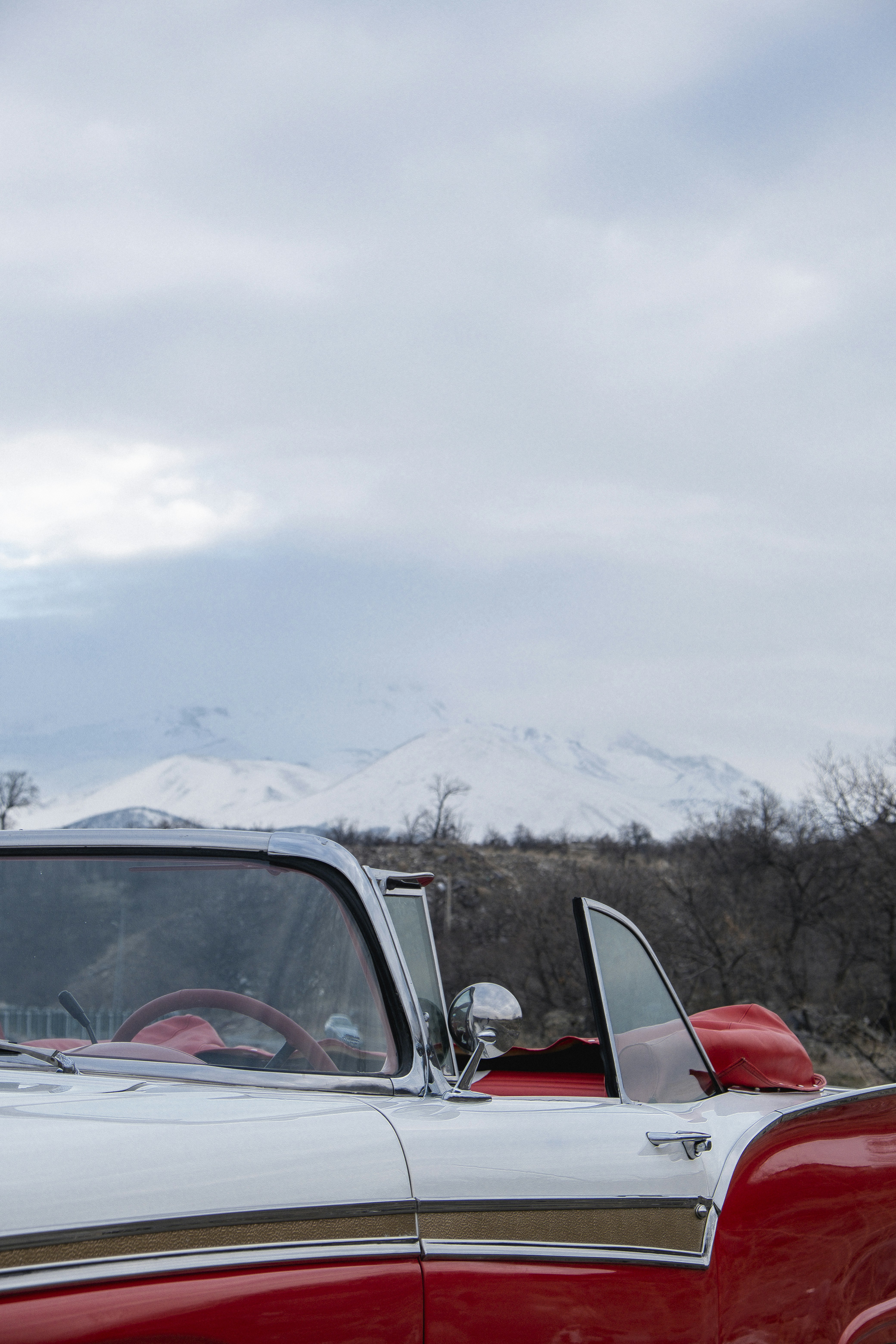 Crimson Convertible Framed by Snow-Dusted Horizon