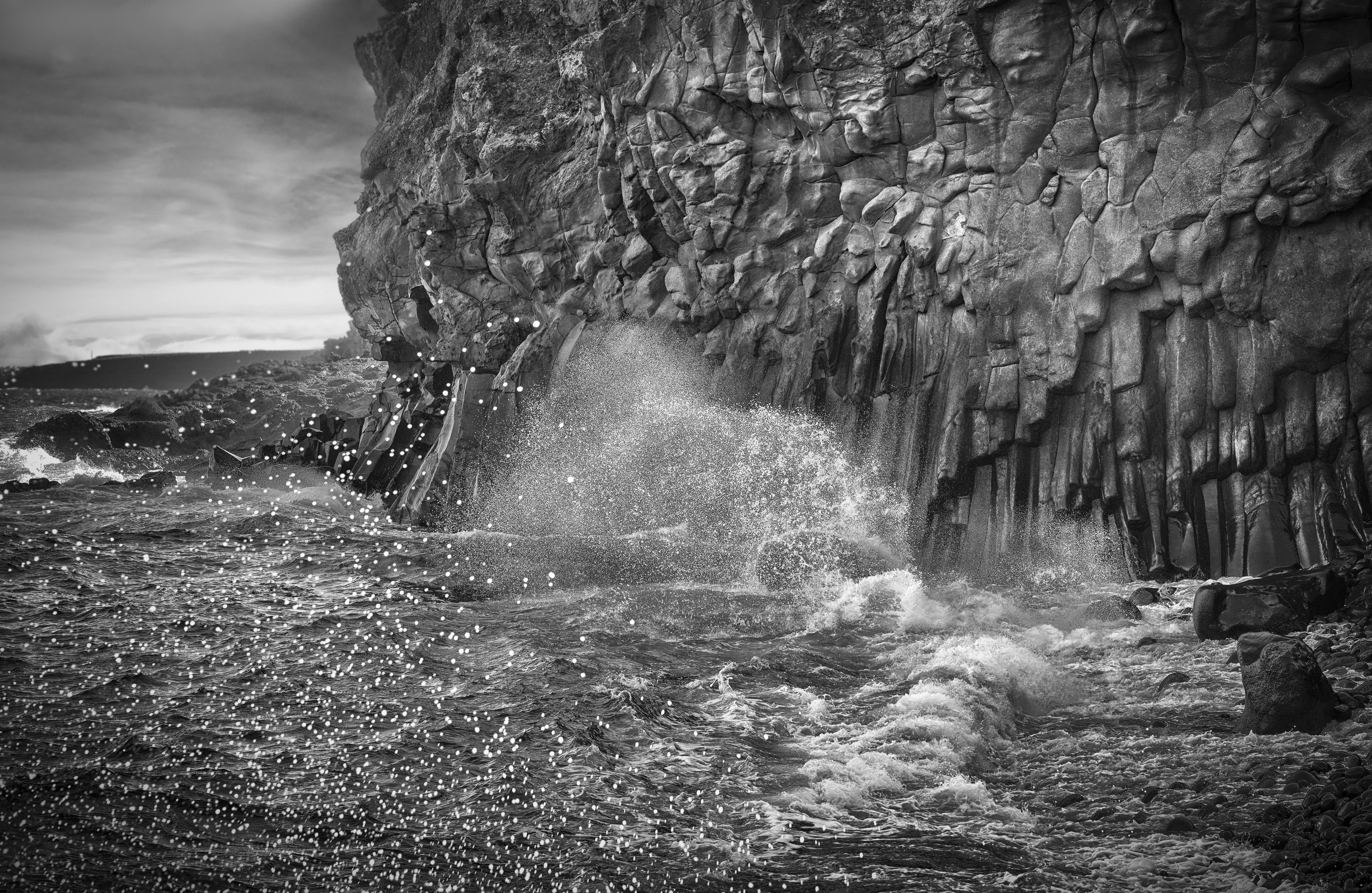 Spray and Stone: Monochrome Clash at a Basalt Cliff