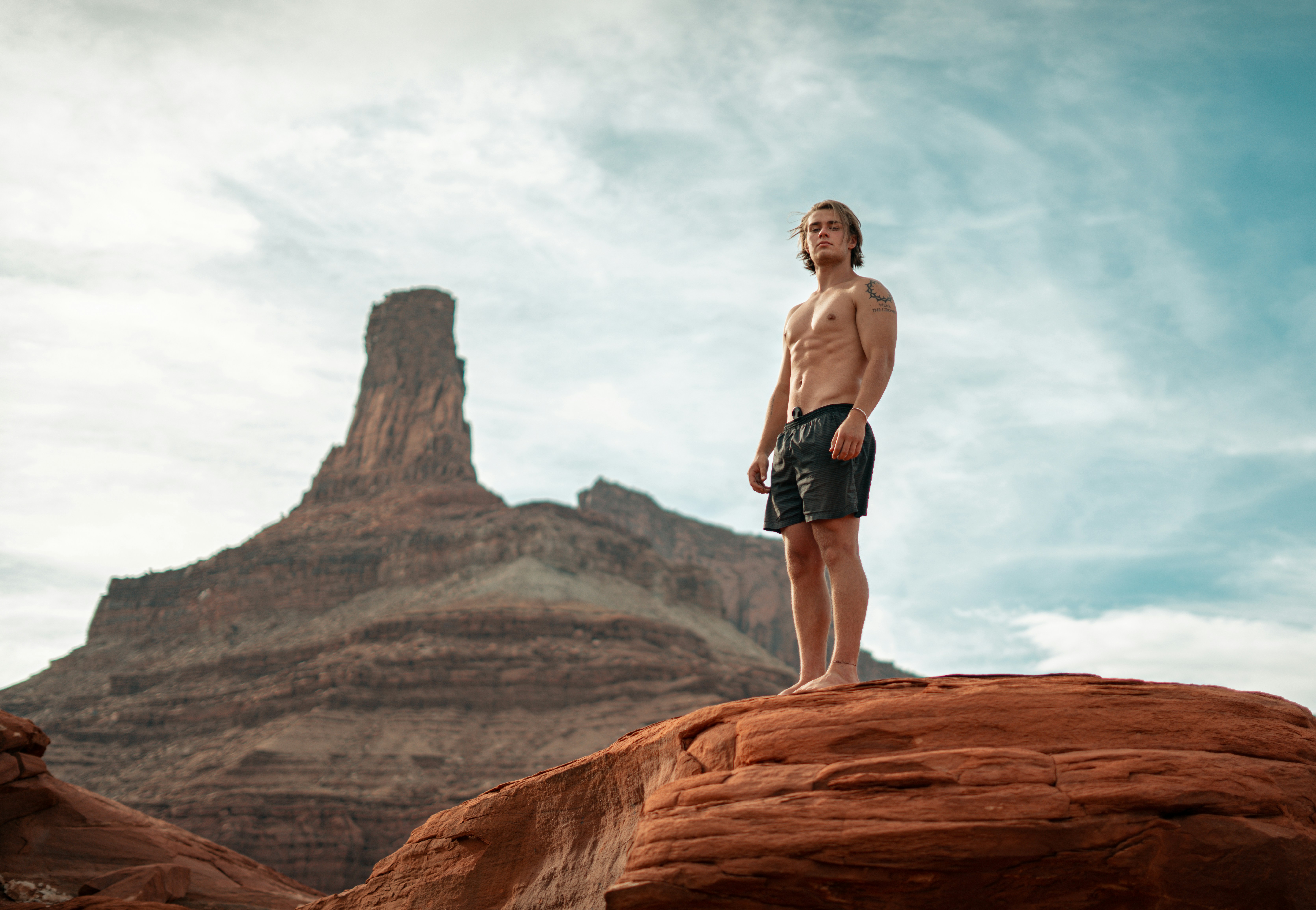 man in black shorts standing on brown rock formation during daytime