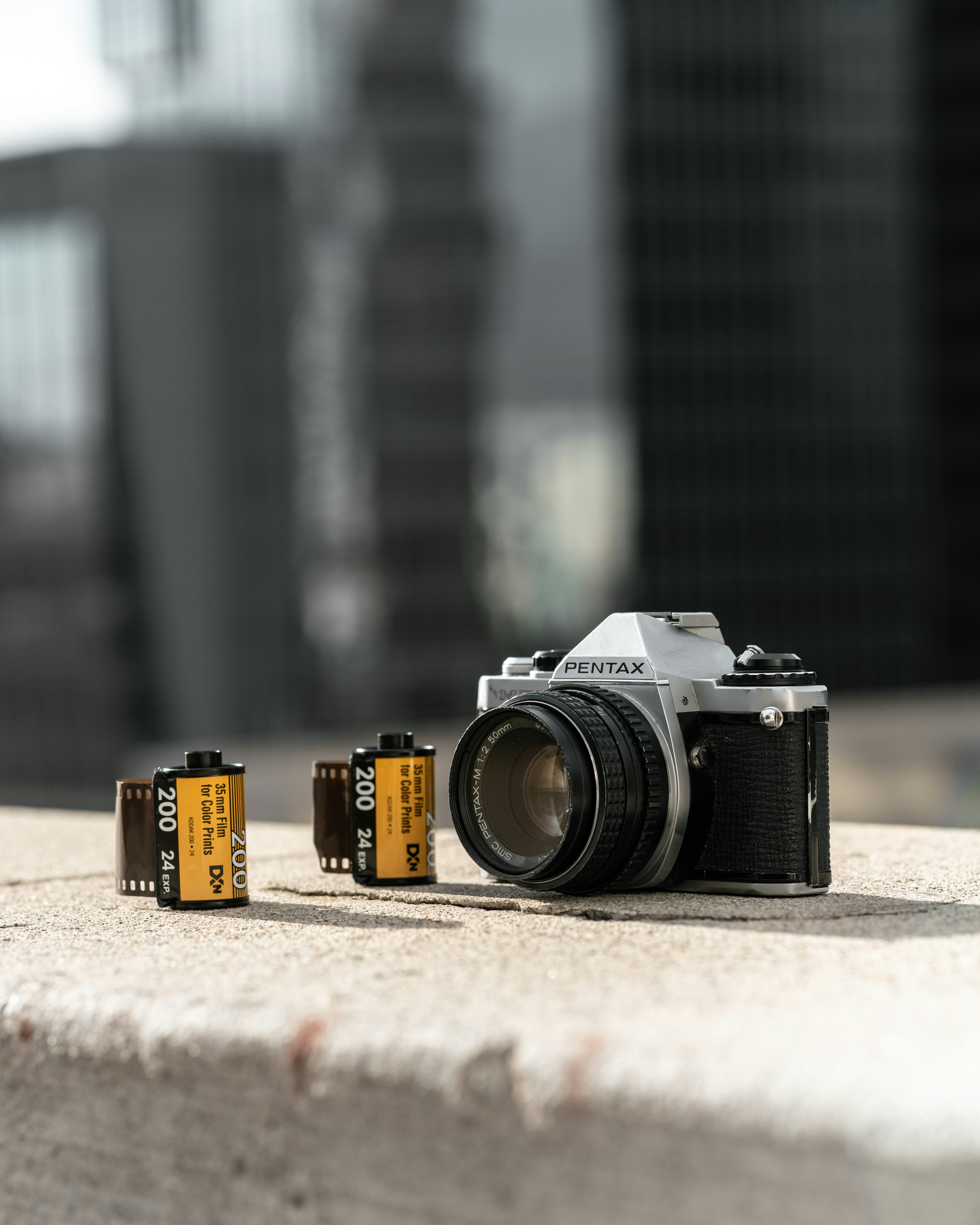Rooftop Still Life: The Silver Pentax and Its Three 35mm Roll Companions