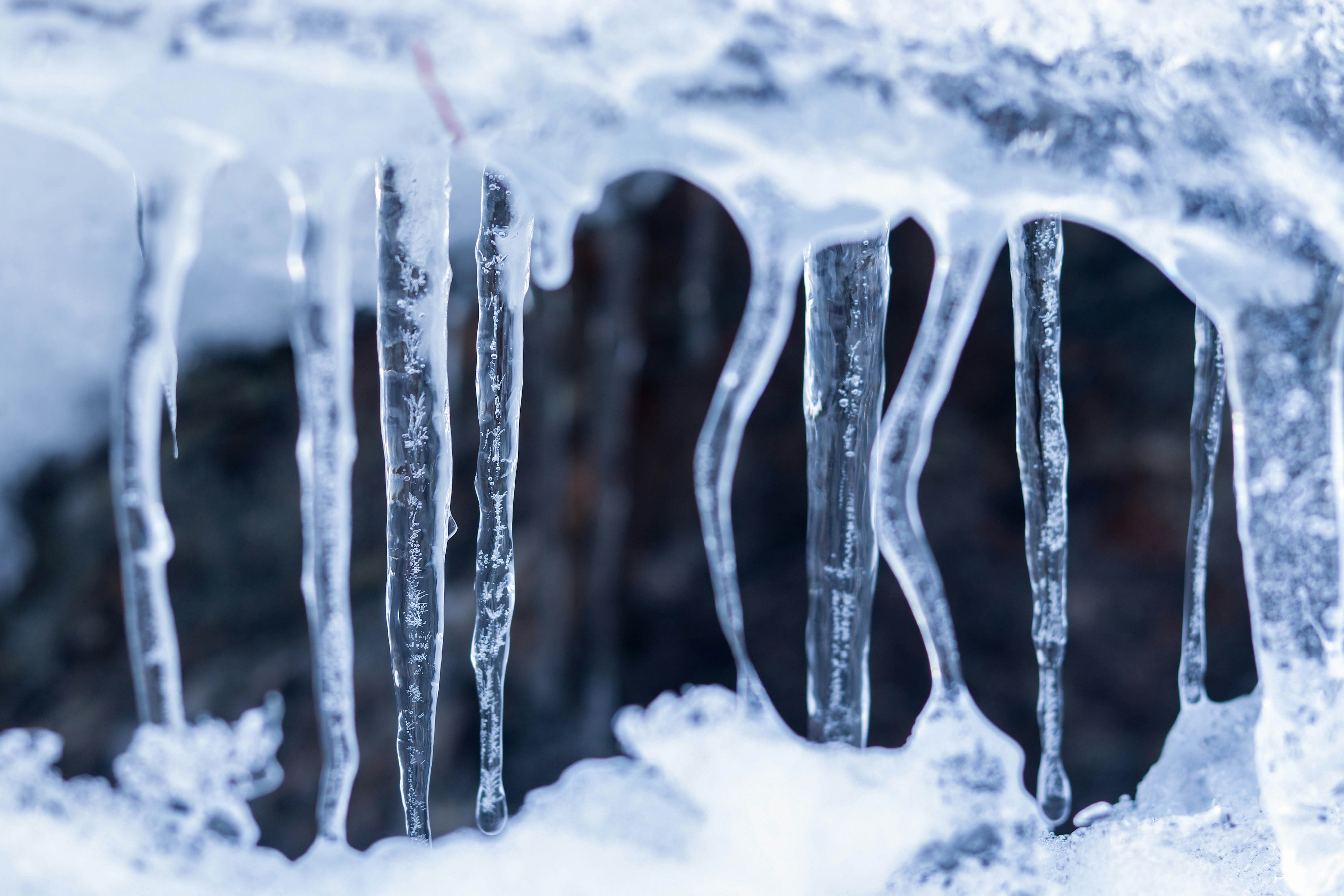 Icicles hanging delicately from a snowy ledge, capturing intricate patterns of frost.