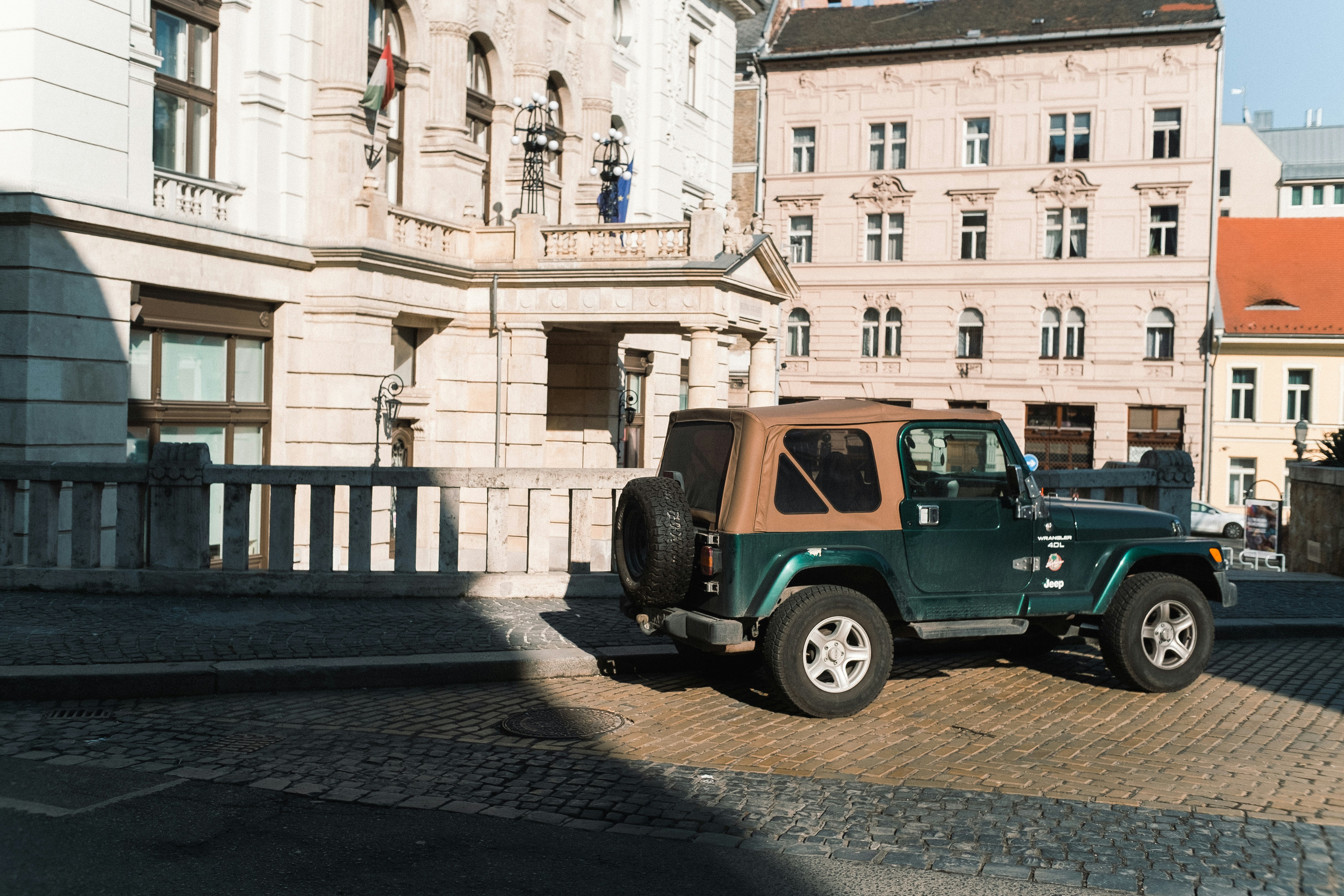 Sunlit Cobblestones and a Jeep: Quiet Urban Rhythm in a European Square