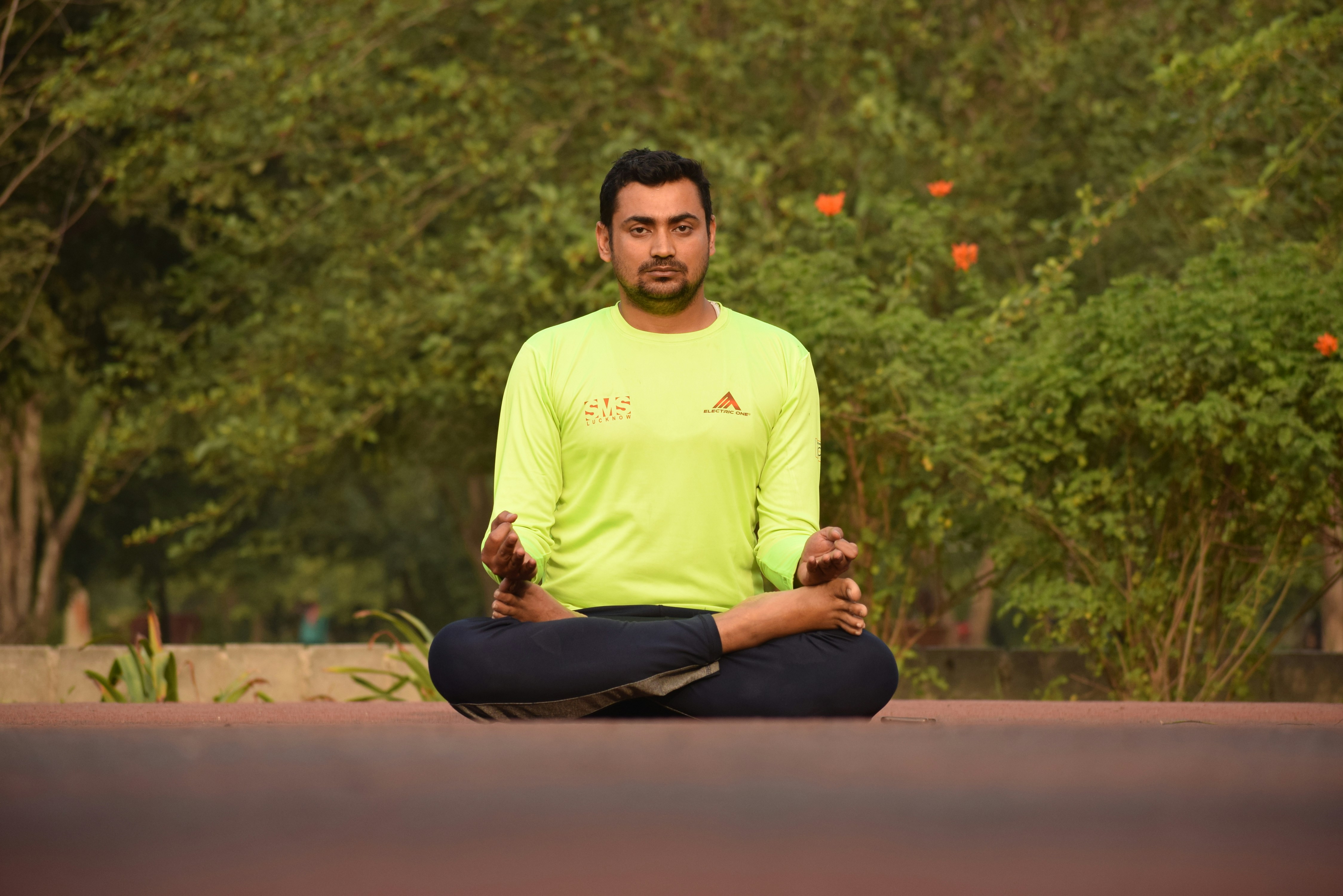 Neon-Clad Meditator on a Garden Stage: Quiet Focus