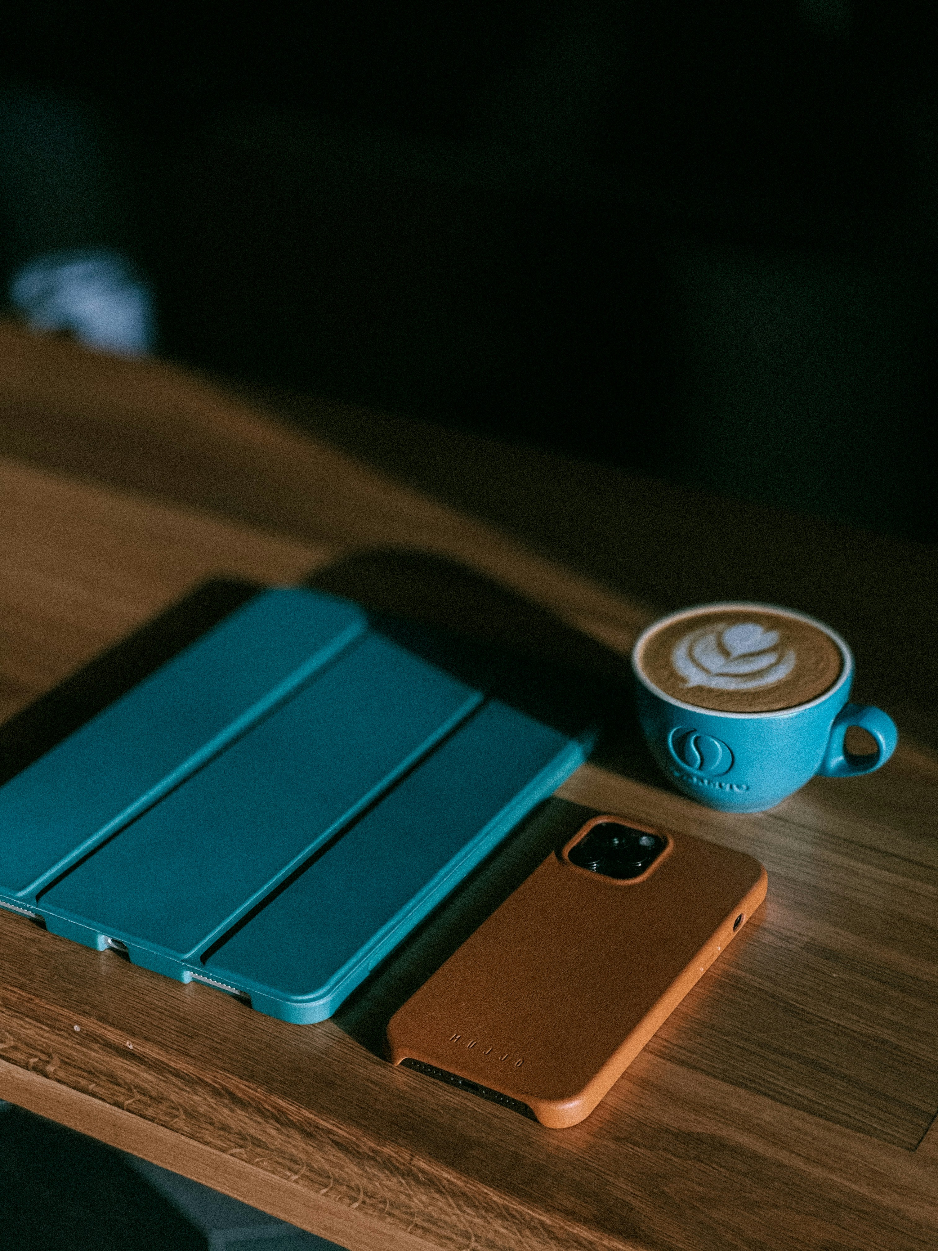 blue and brown leather flip case on brown wooden table
