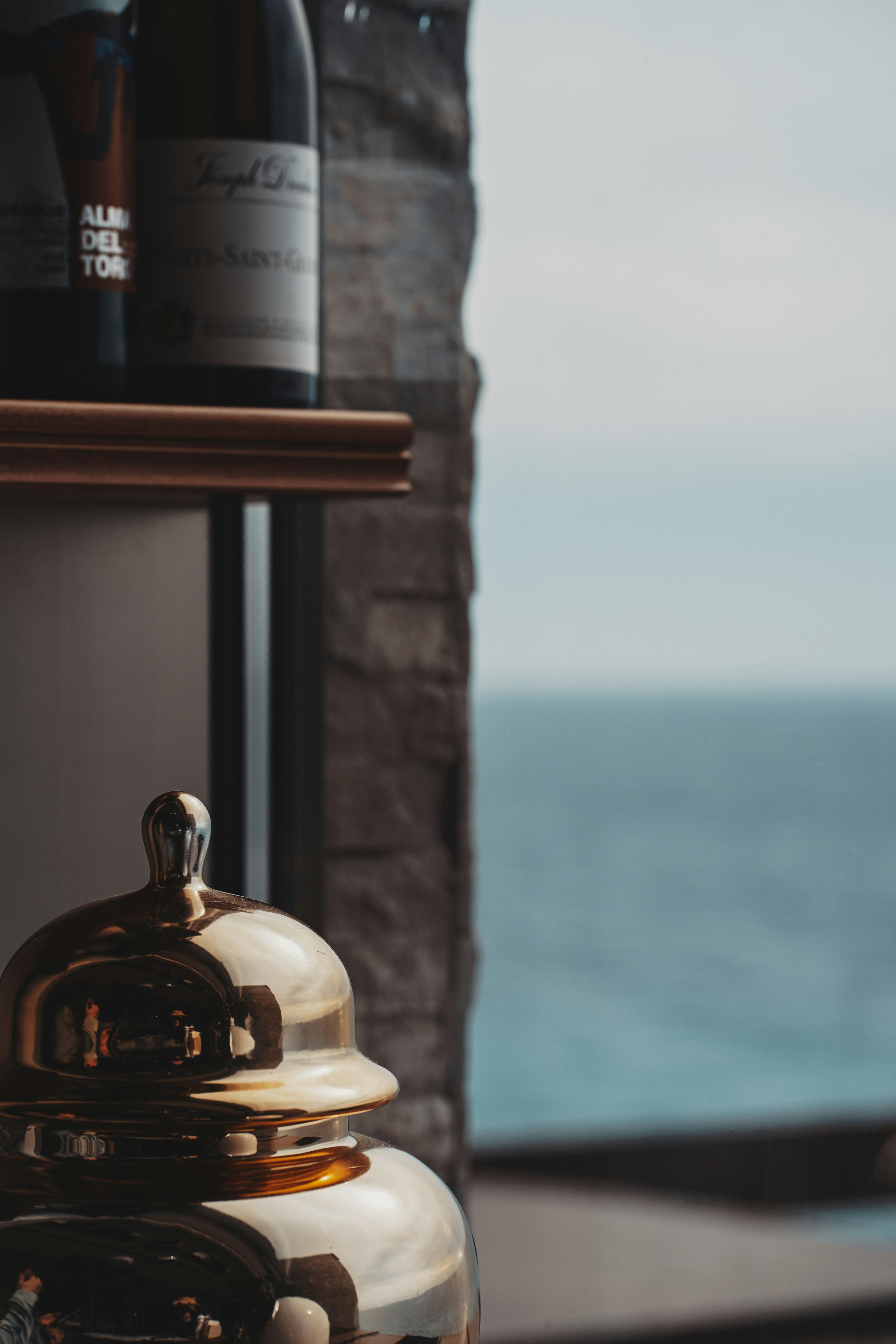 Brass Jar at the Edge: Quiet Luxury Framed by Ocean Light
