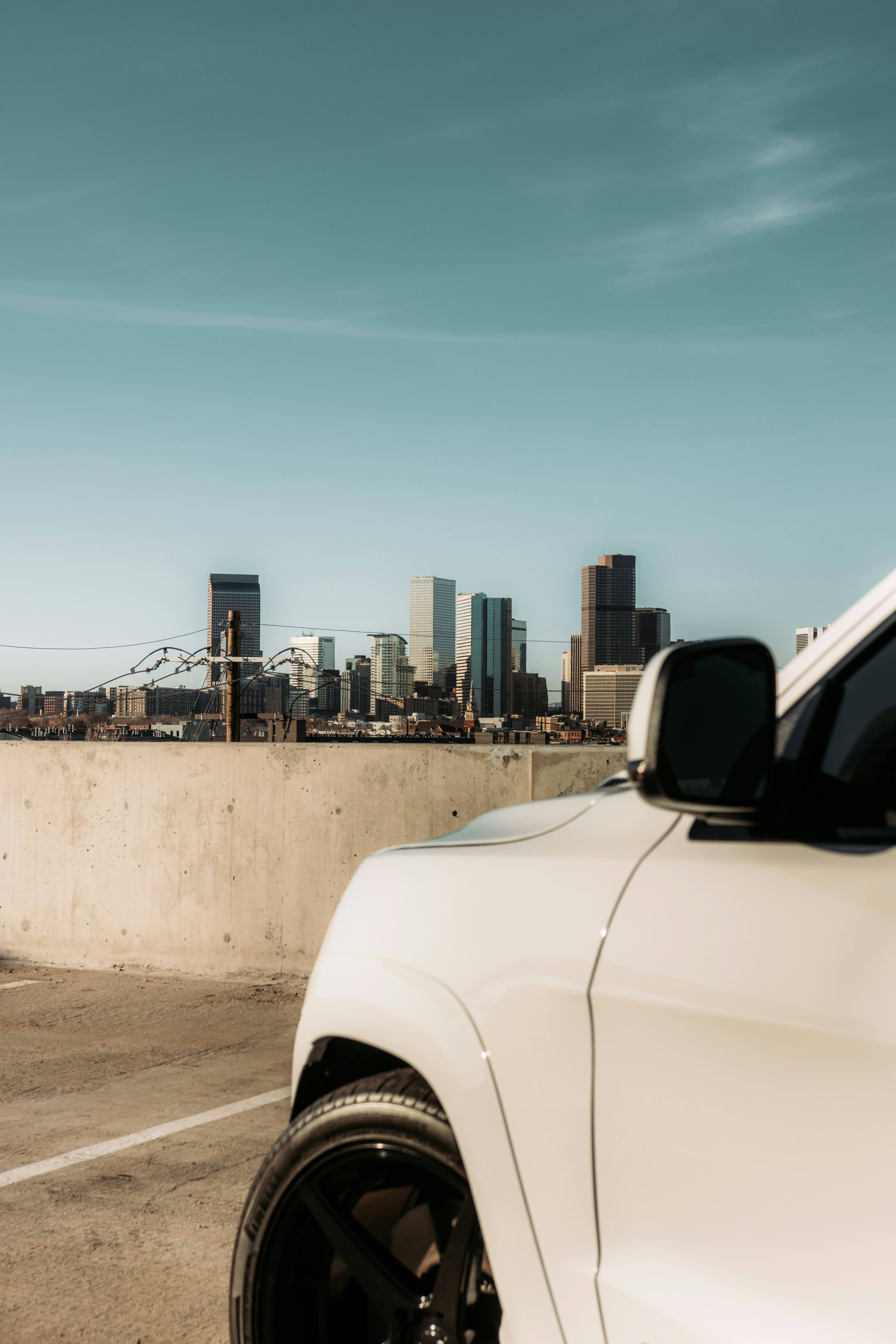 Urban Skyline Emerges Behind a White Vehicle on a Rooftop