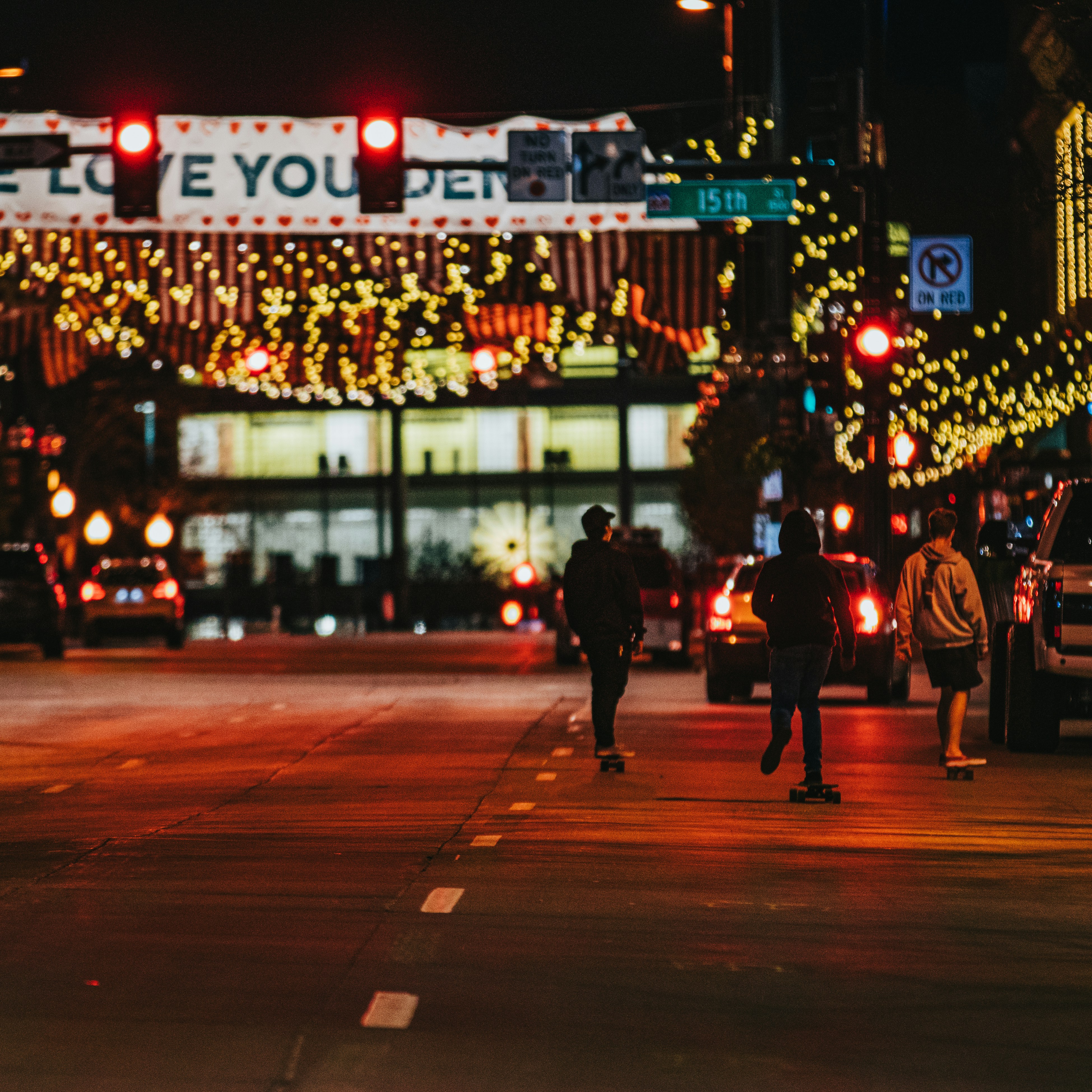 Three Pedestrians Under Festoon Lights on a Quiet City Night