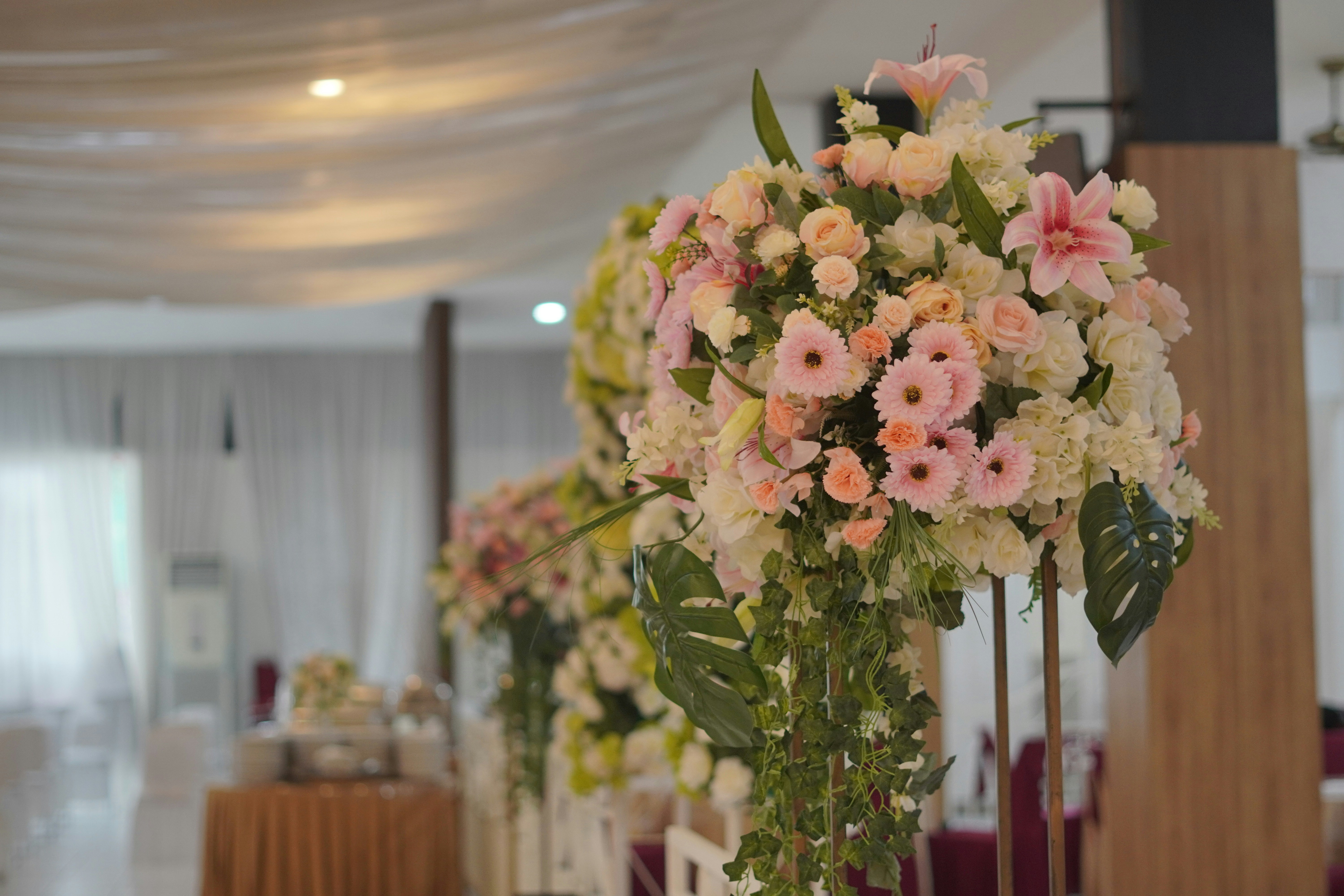 Rosy floral cascade centerpiece rising above a softly lit banquet hall