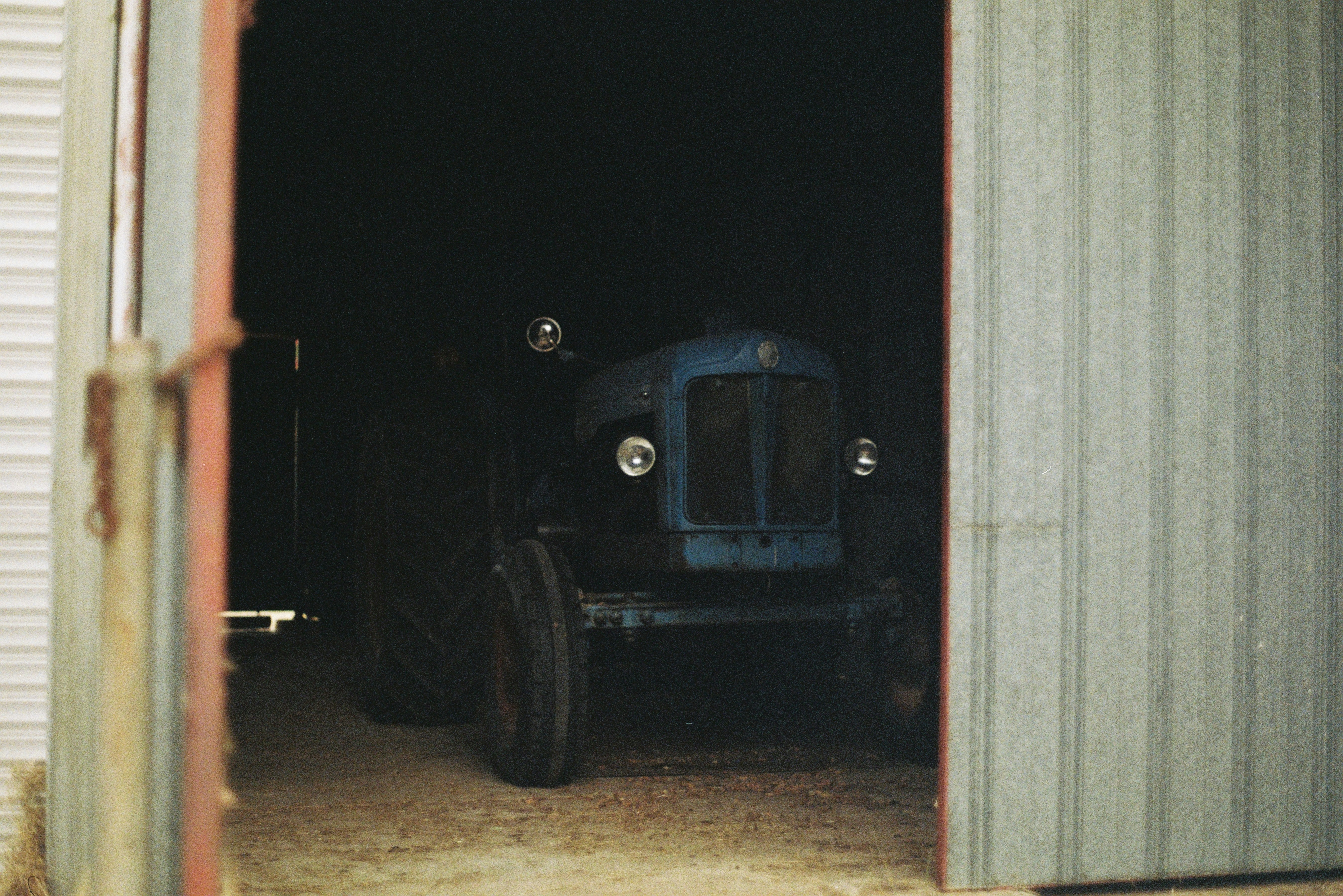 Blue Tractor at the Shed’s Edge: Quiet Rust and Emerging Light